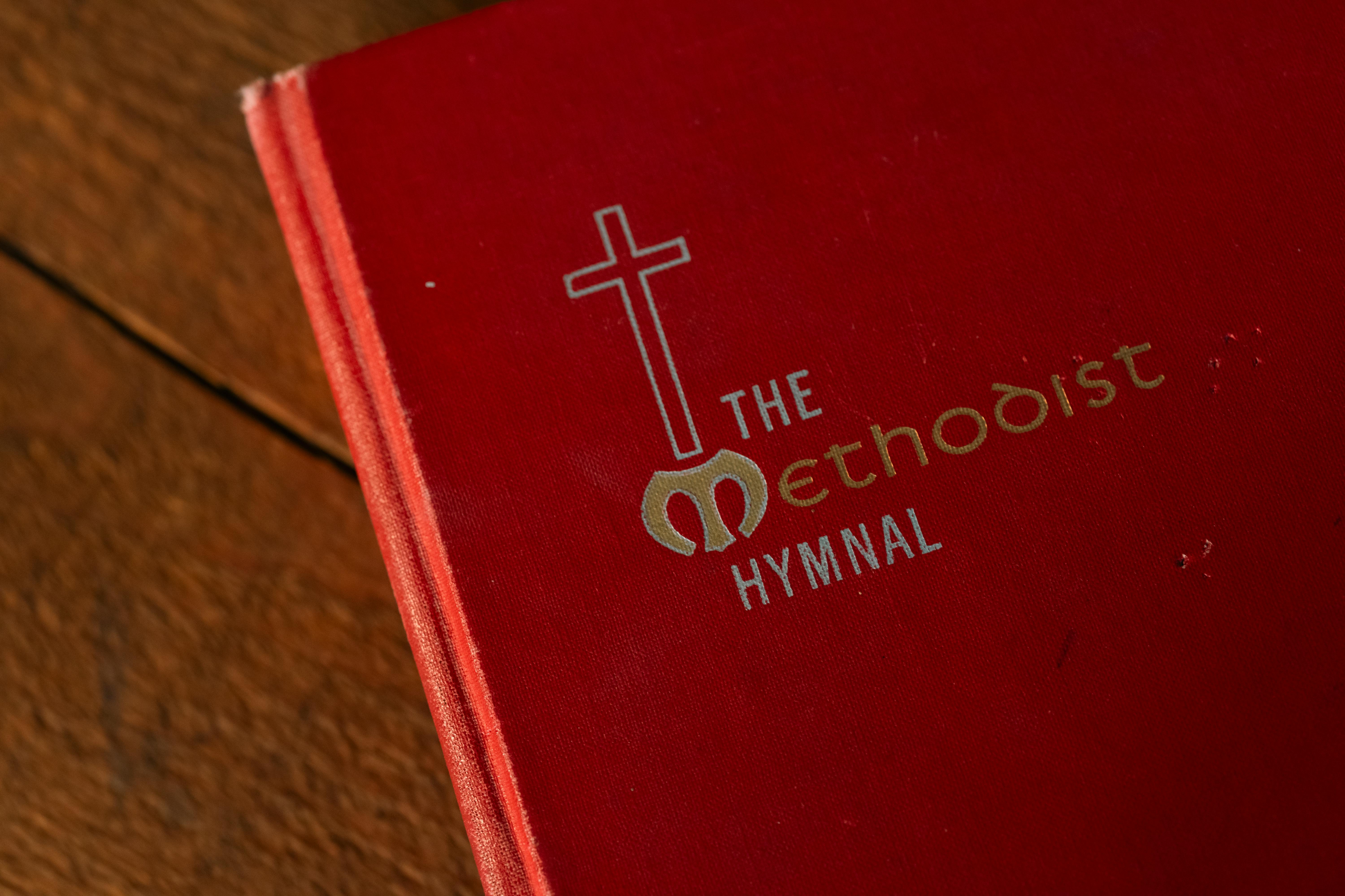 Close-up of a Red Methodist Hymnal on Wood Surface · Free Stock Photo