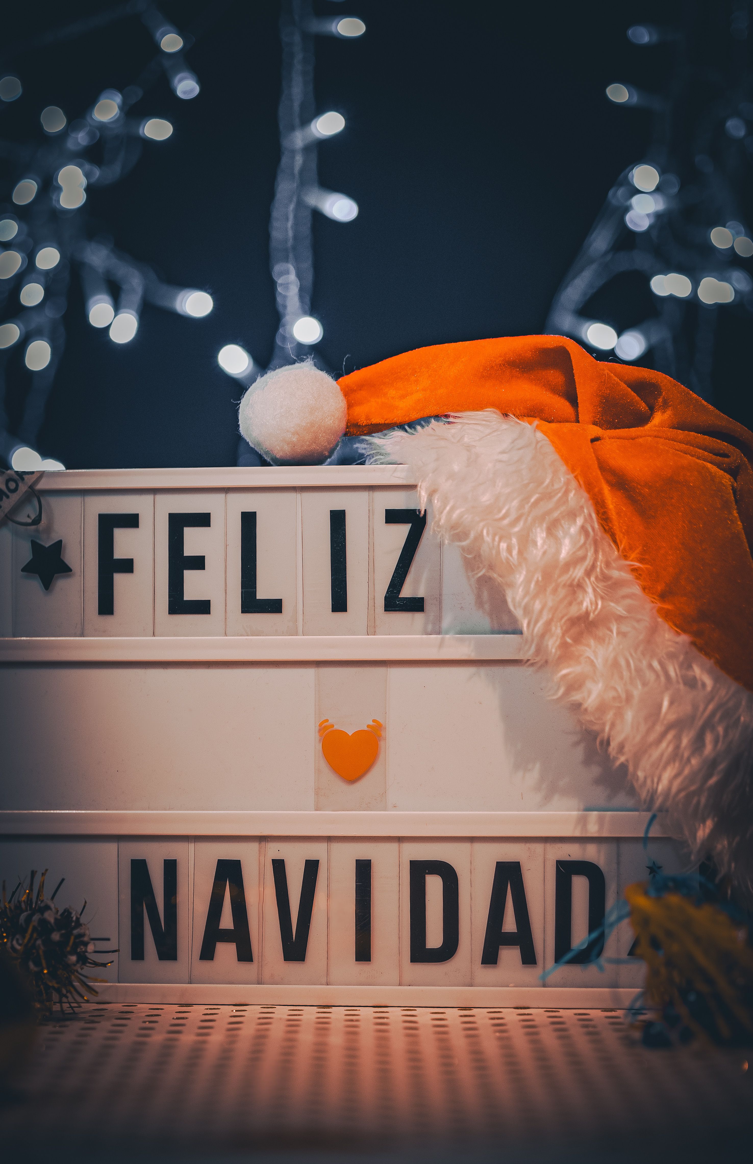 Festive Christmas Sign with Santa Hat and Lights · Free Stock Photo