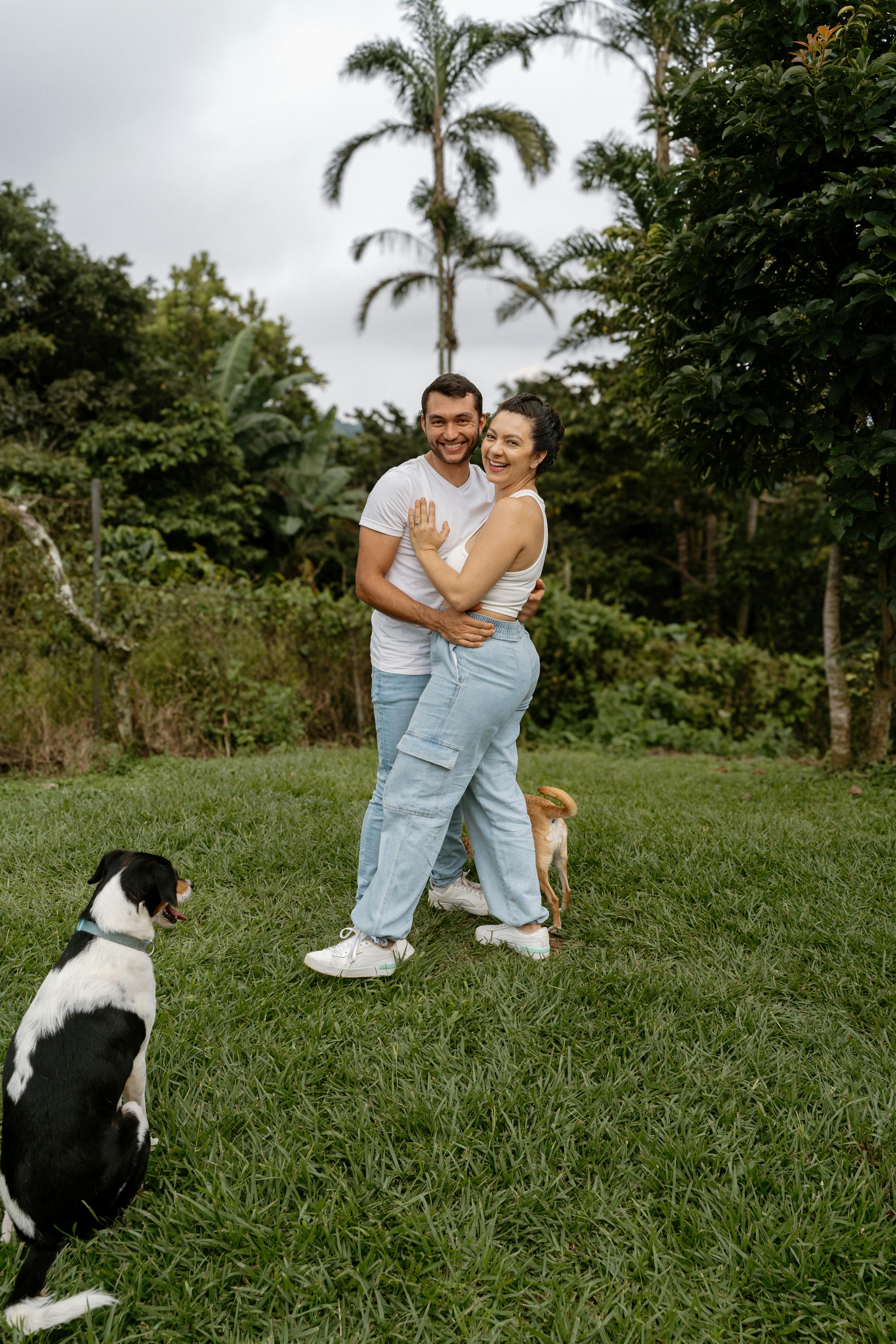 Couple Embracing Outdoors with Dogs in Costa Rica · Free Stock Photo