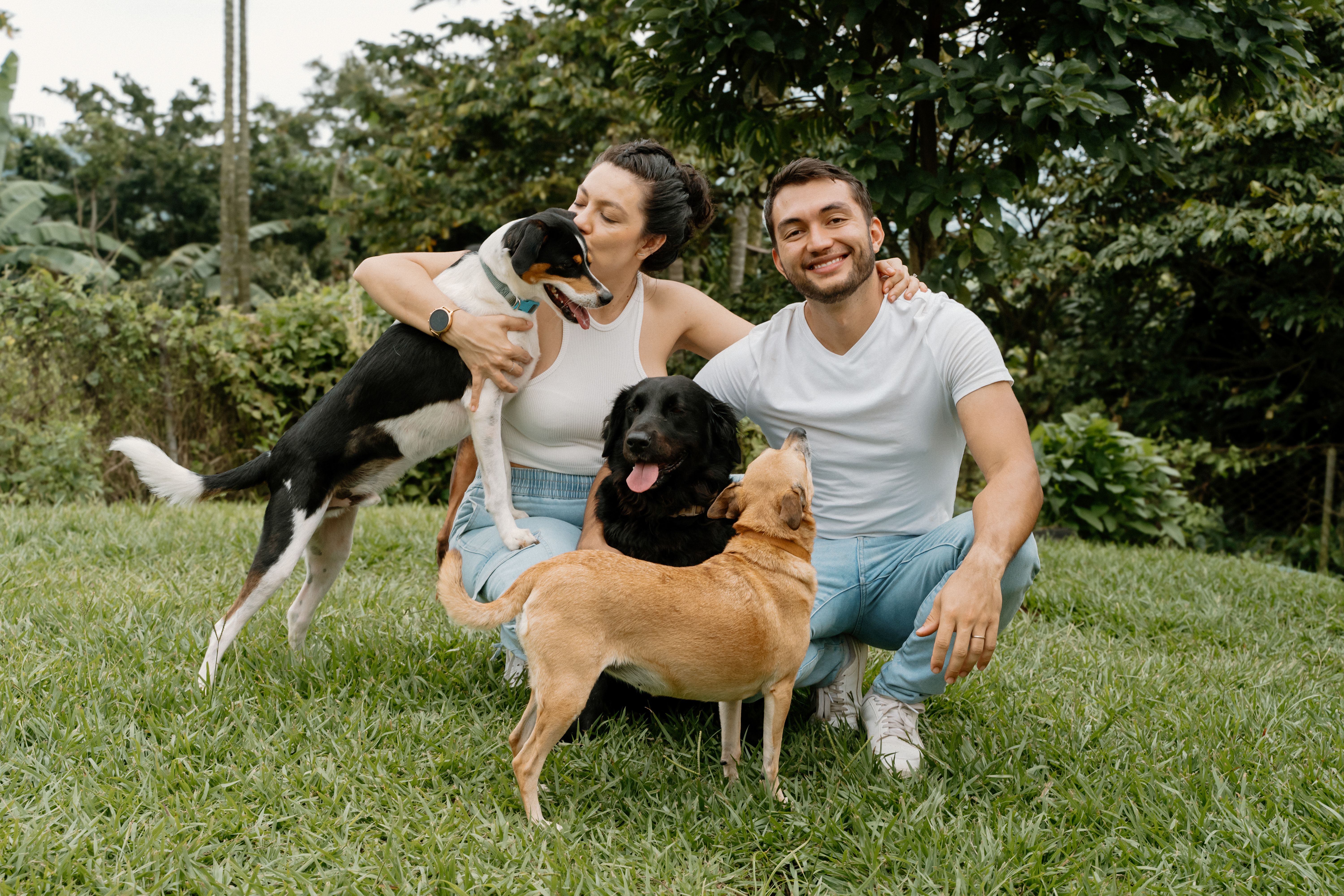 Feliz Pareja Con Perros En Un Jardín De Costa Rica · Foto de stock gratuita