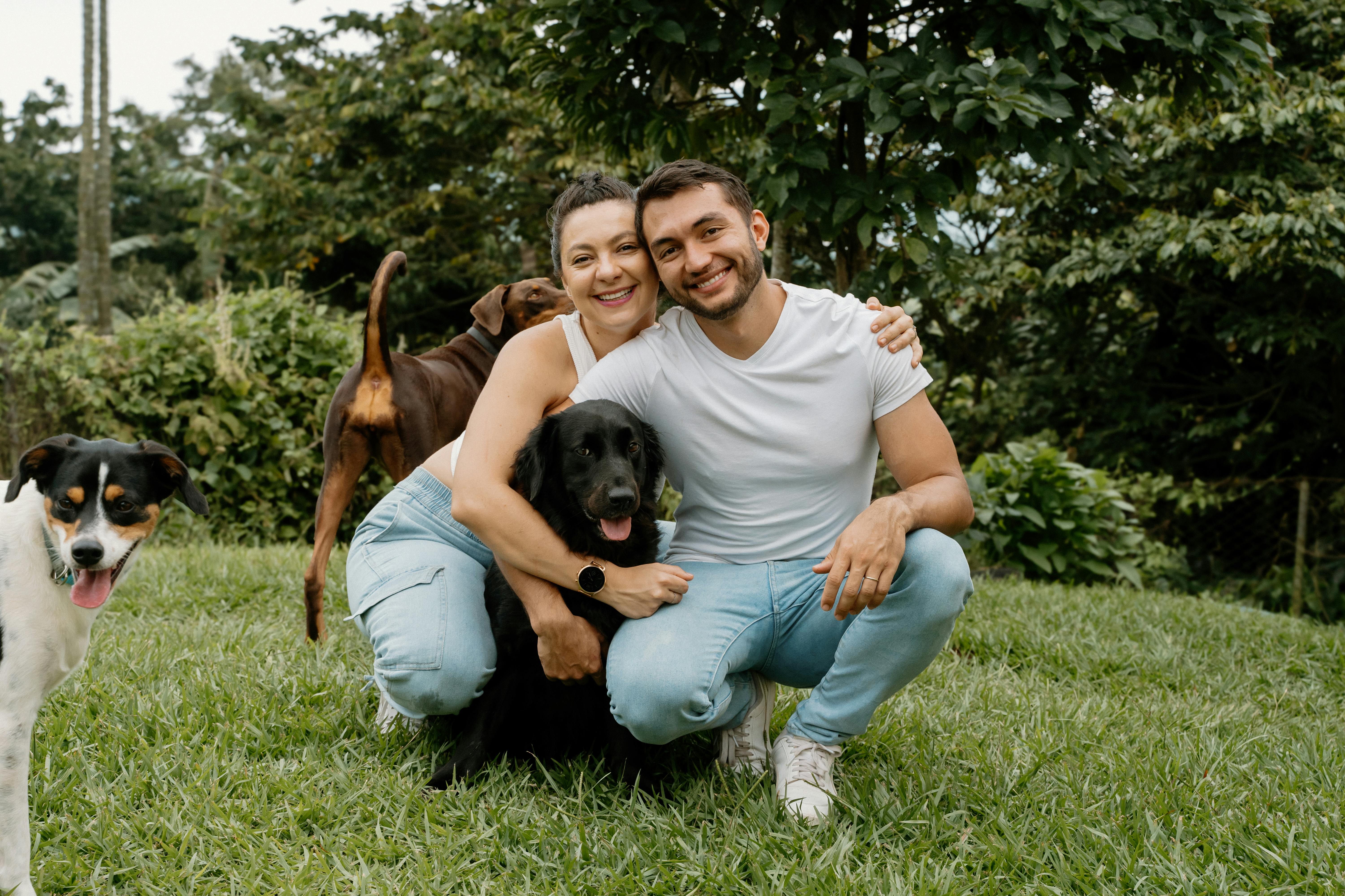 Happy Couple with Dogs in a Costa Rican Garden · Free Stock Photo