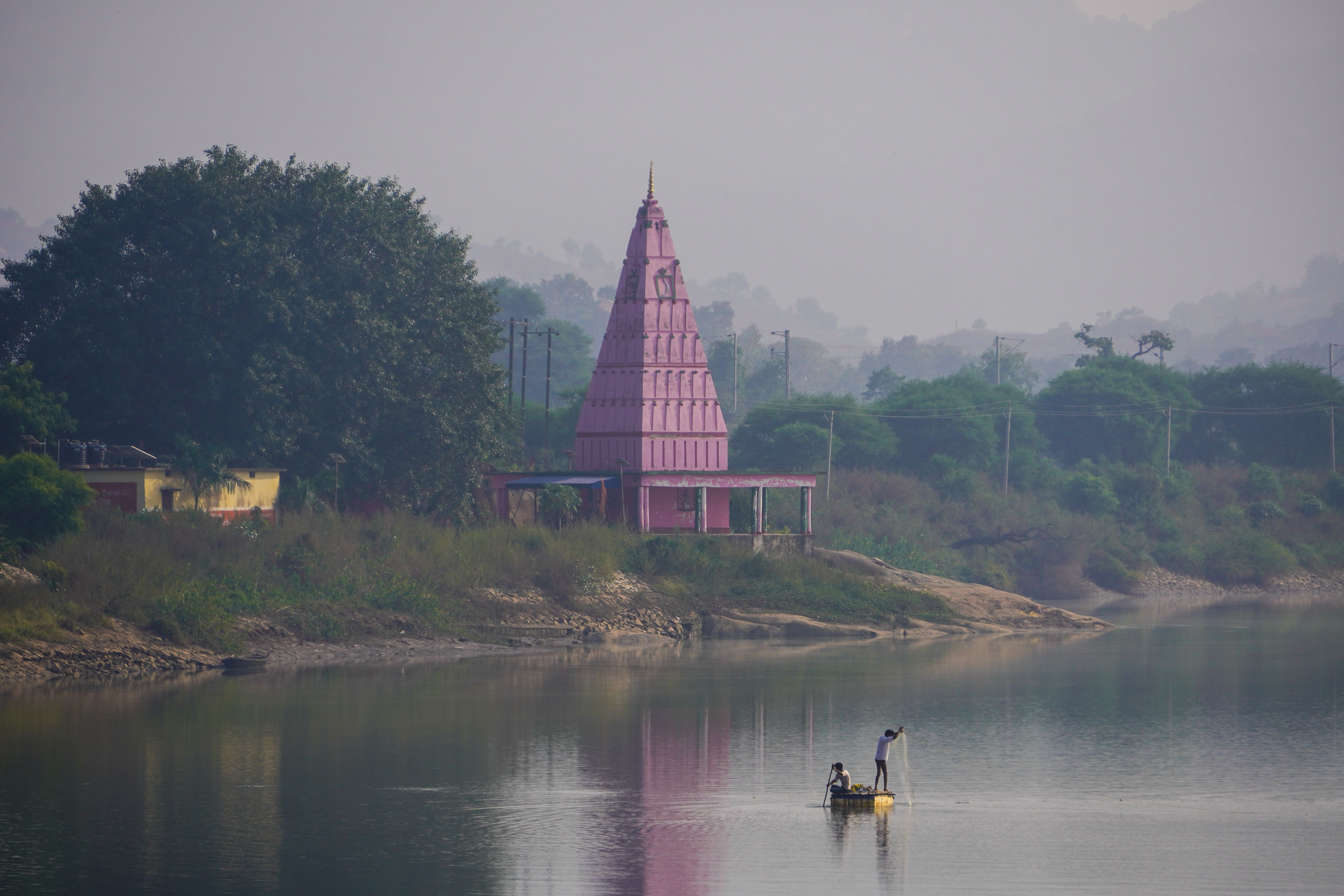 Serene Temple by River with Boat at Dawn · Free Stock Photo