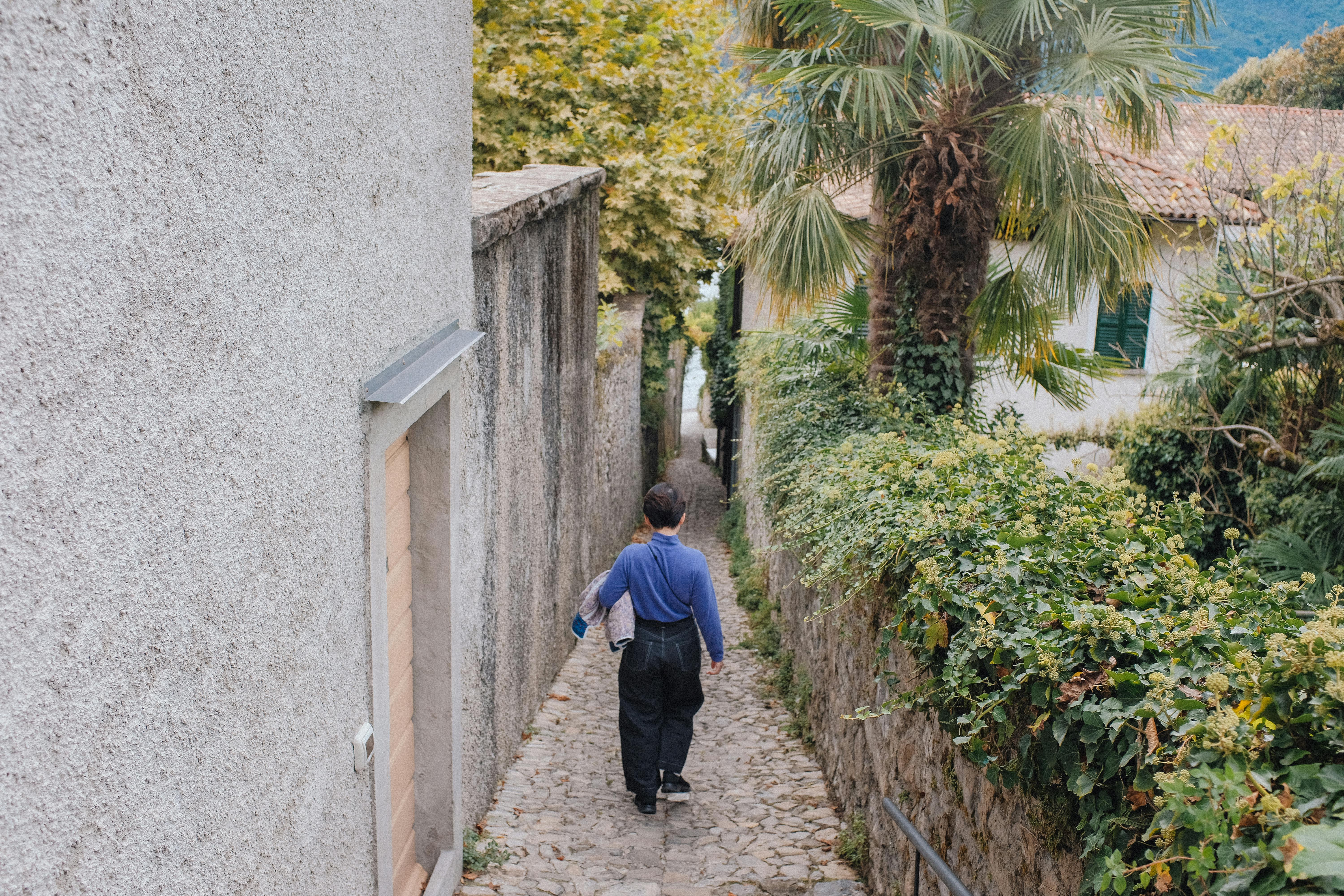 Person Strolling Down Scenic European Alley · Free Stock Photo