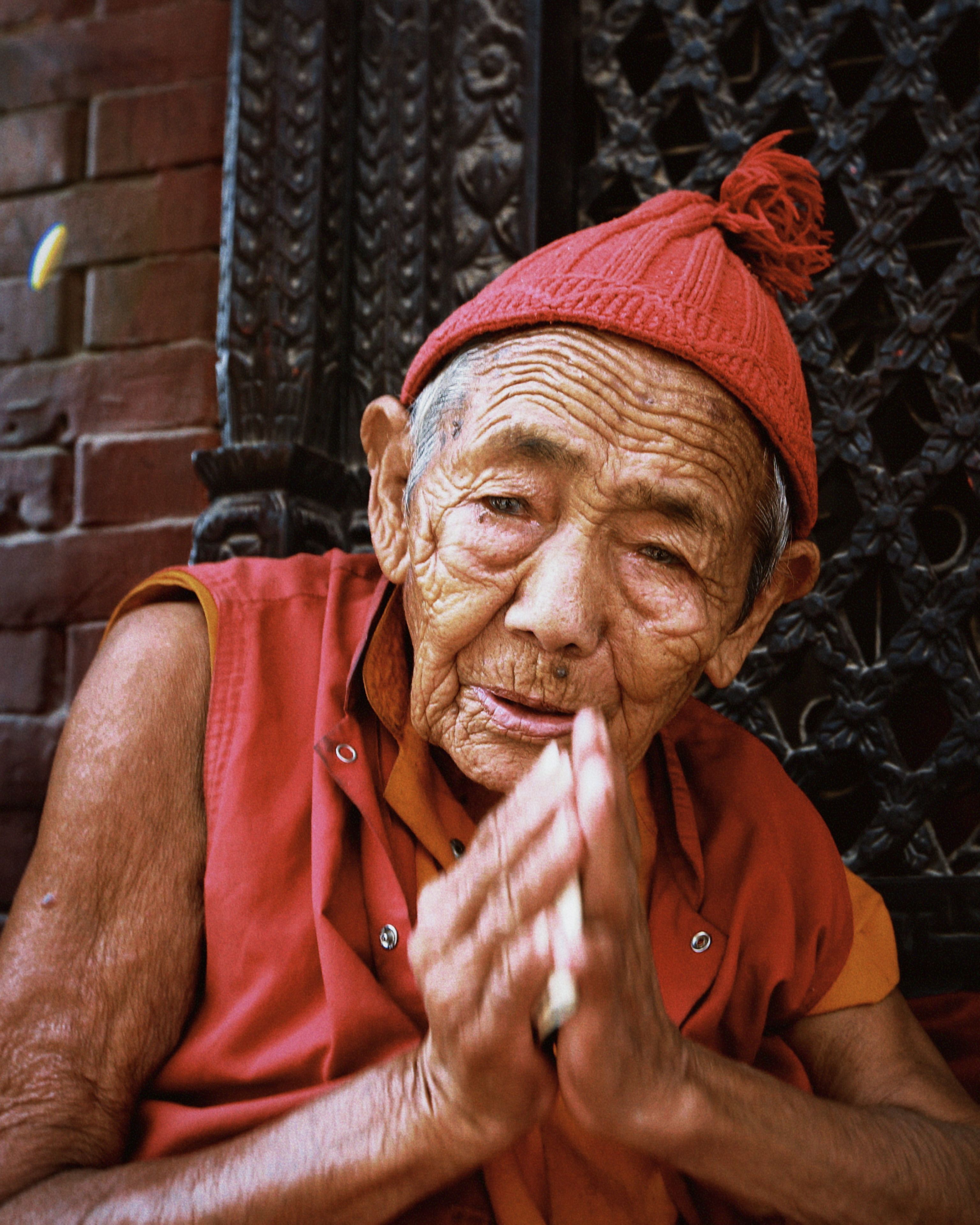 Elderly Monk in Traditional Red Attire · Free Stock Photo