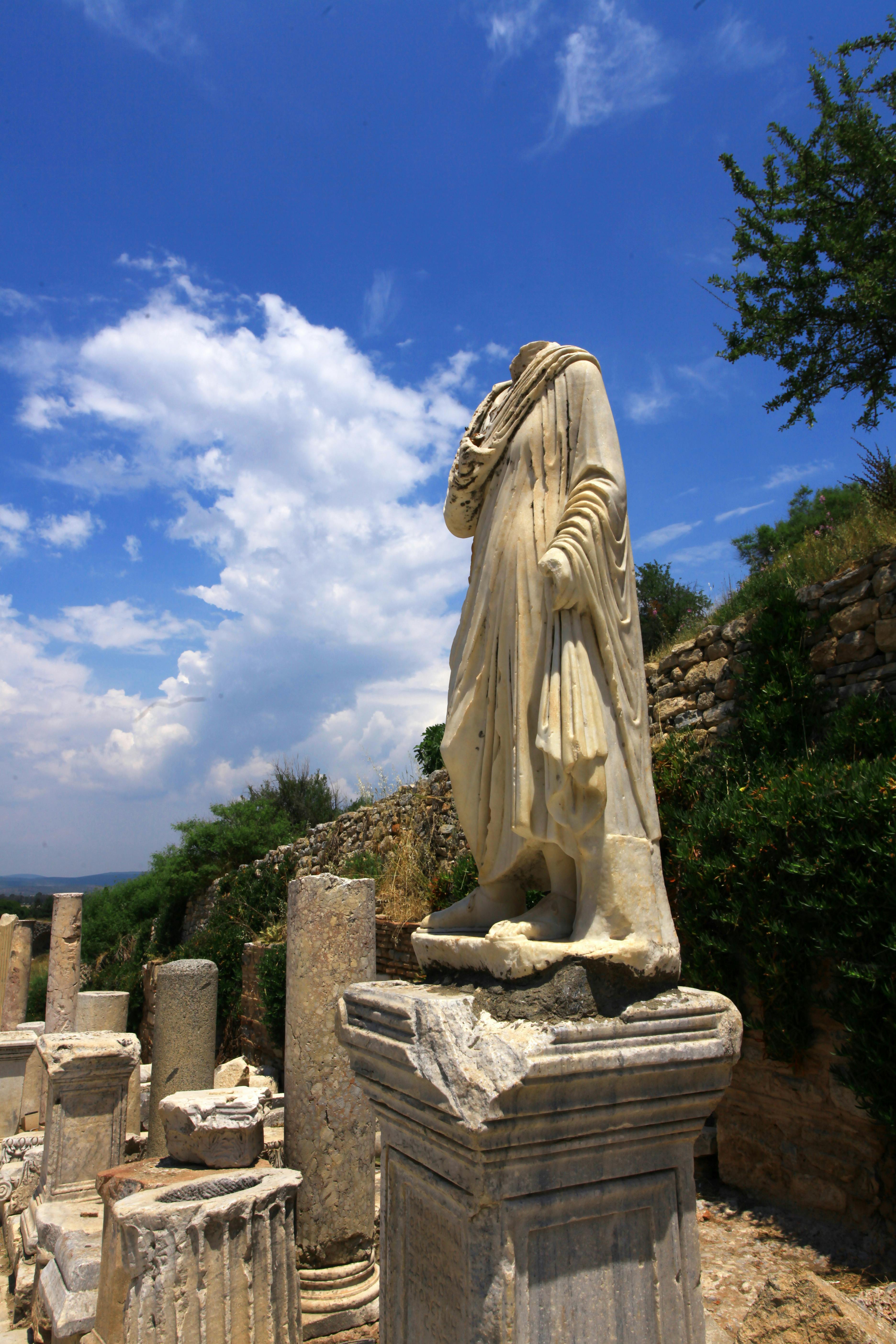 Ancient Headless Statue Amidst Ruins Under Blue Sky · Free Stock Photo