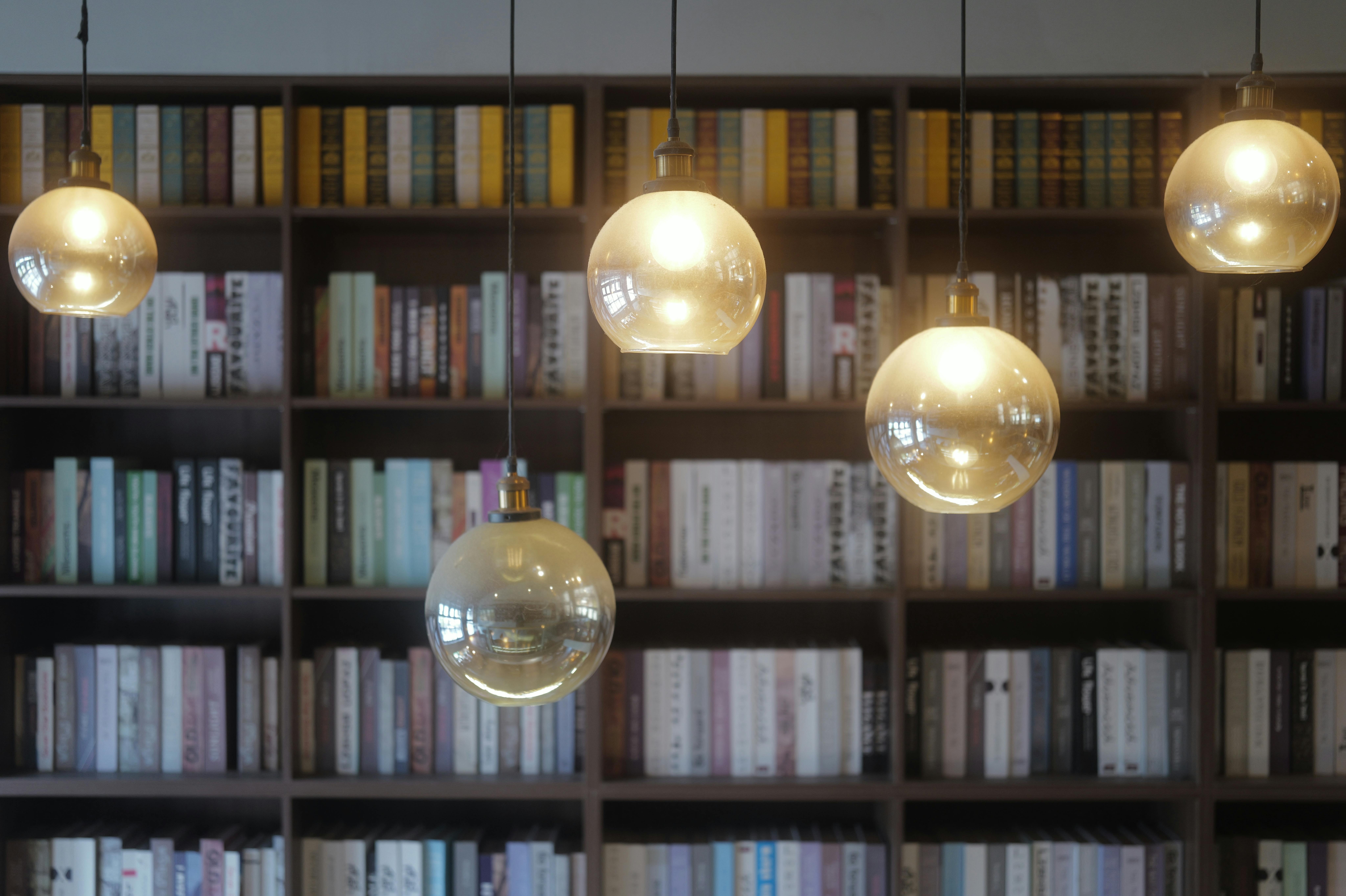Cozy Library with Hanging Light Bulbs · Free Stock Photo