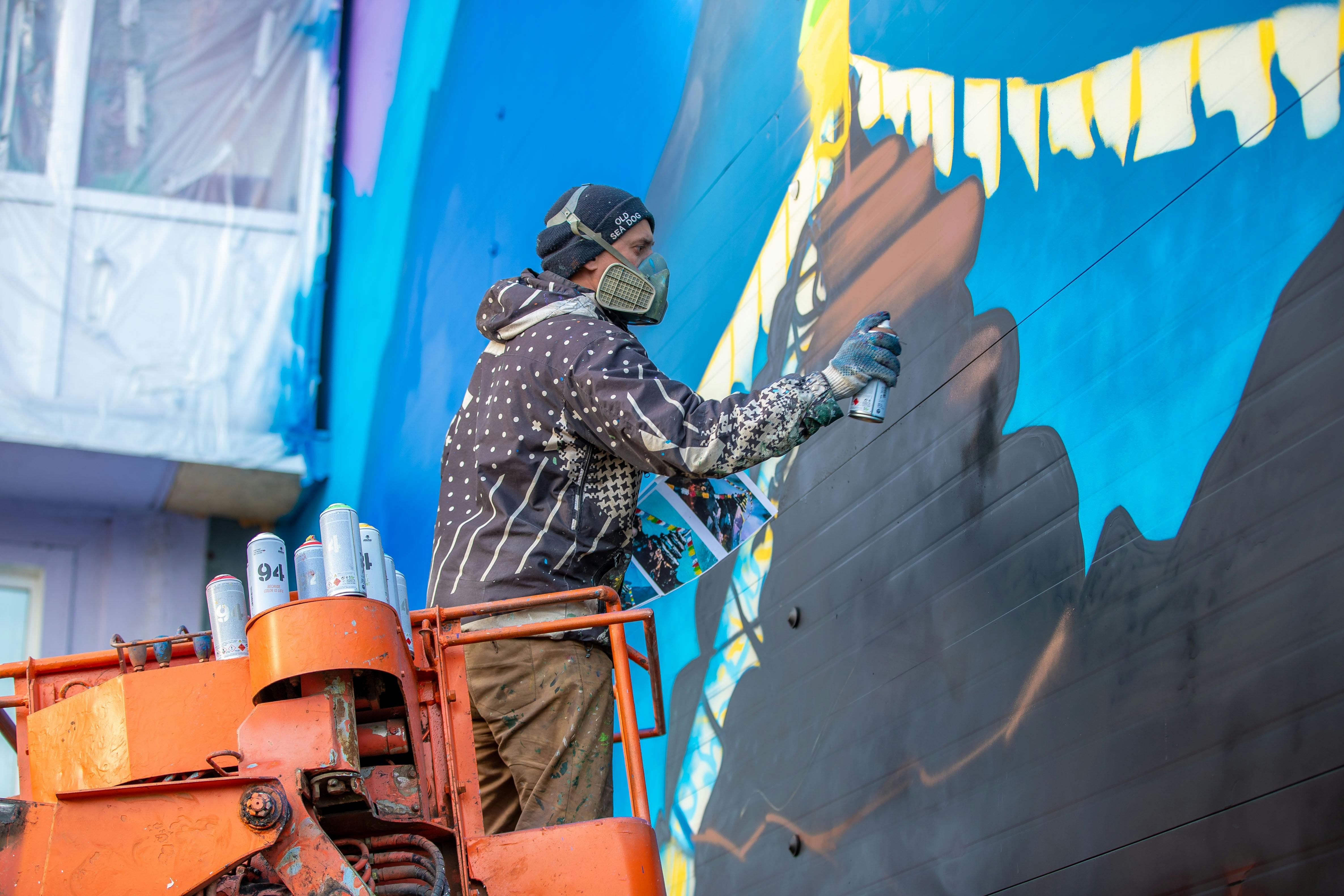 Street Artist Creating Vibrant Mural on Building Wall · Free Stock Photo