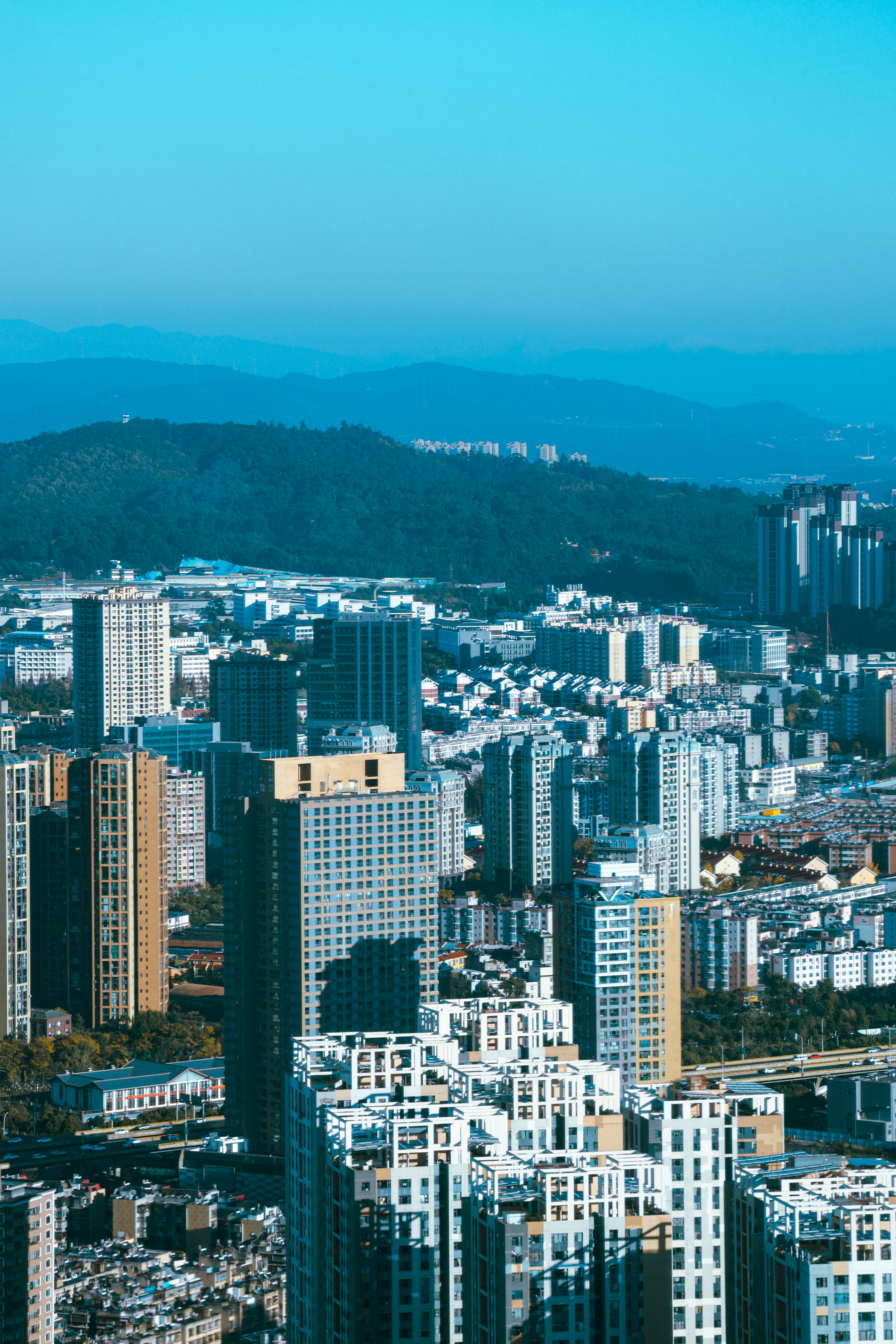 Aerial View of Modern Urban Cityscape with Mountains · Free Stock Photo