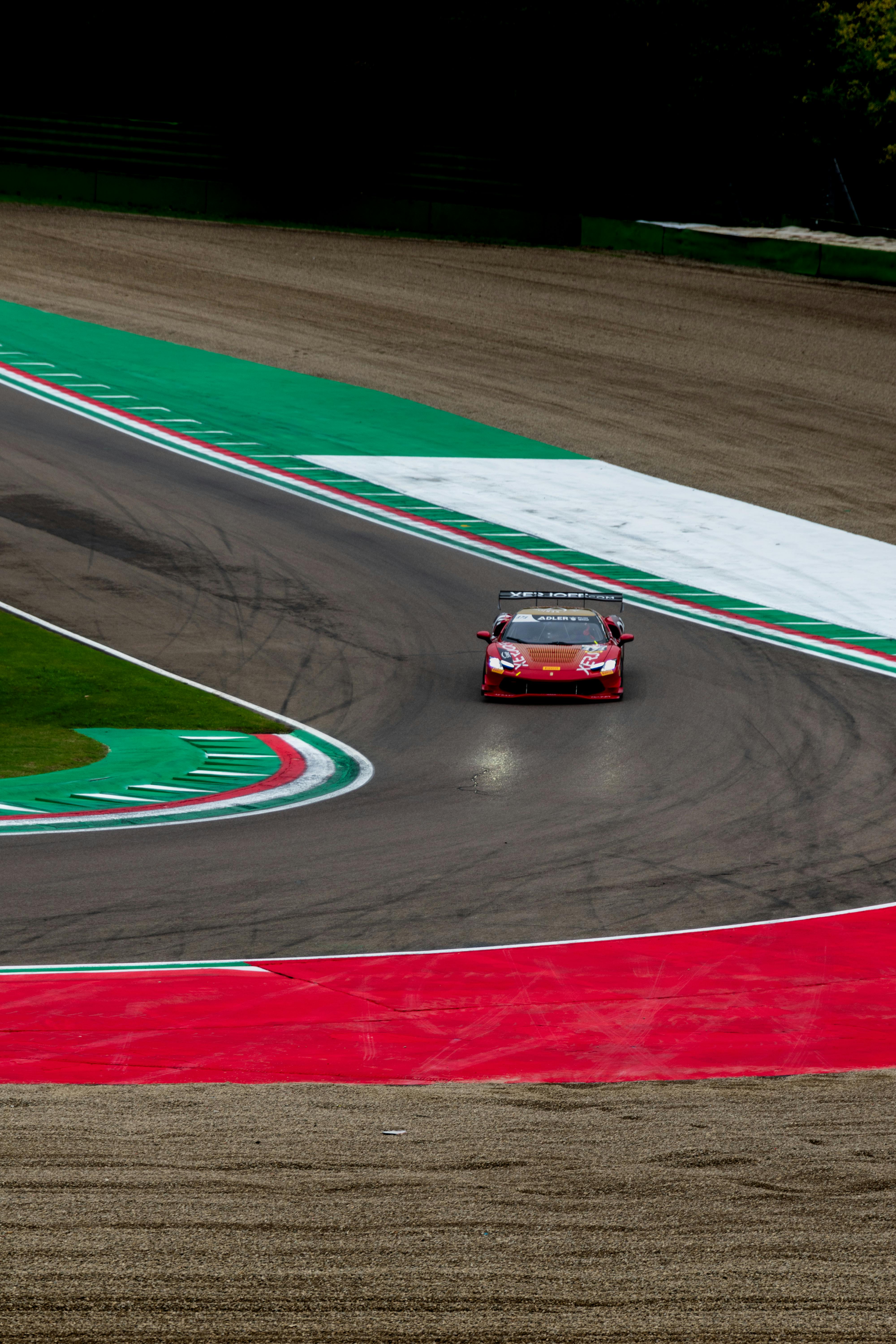 Red Sports Car Racing on Curved Track · Free Stock Photo