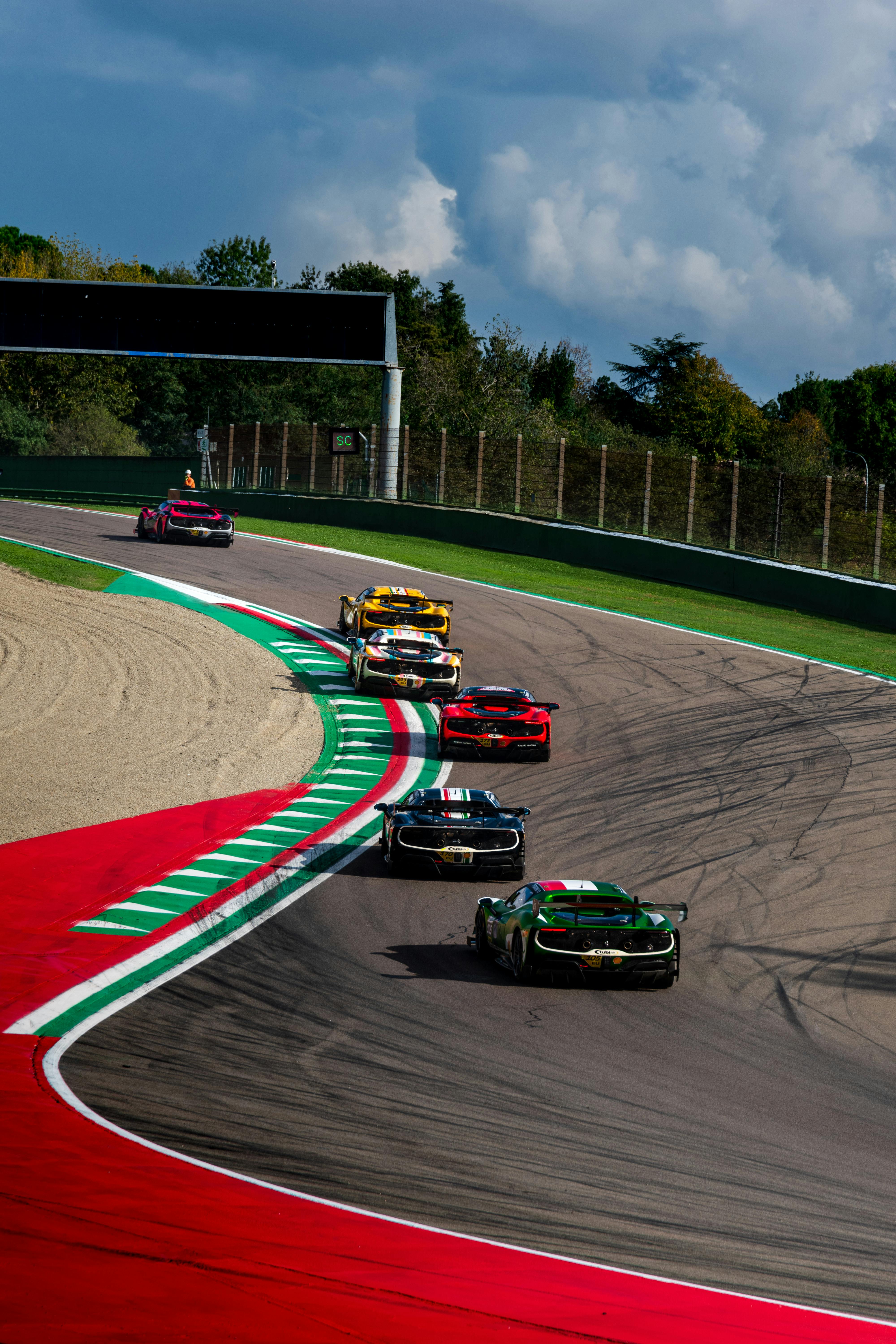 High-Speed Car Racing on Curved Track · Free Stock Photo