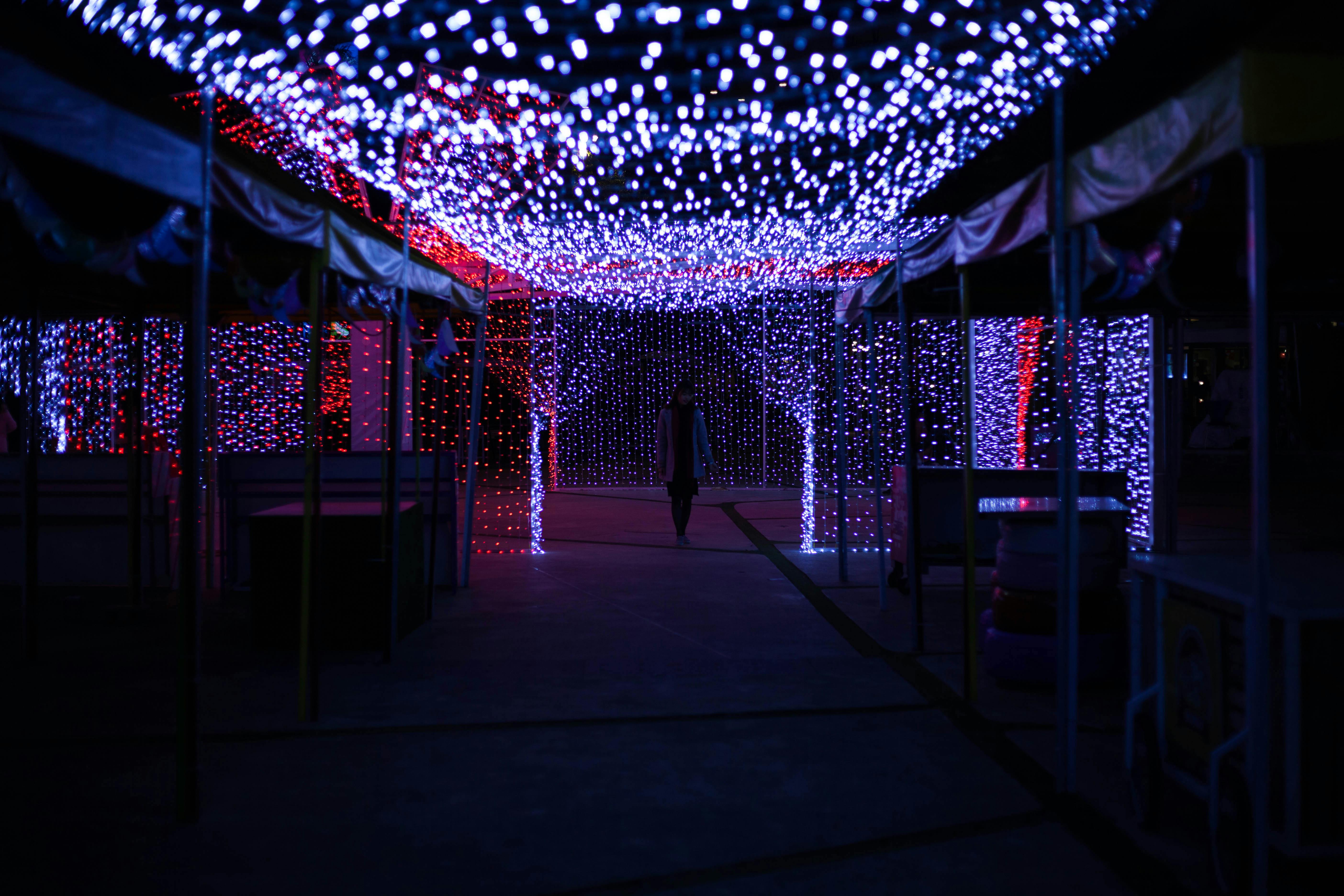 People Walking on Pathway With Lights Turned on during Night Time ...