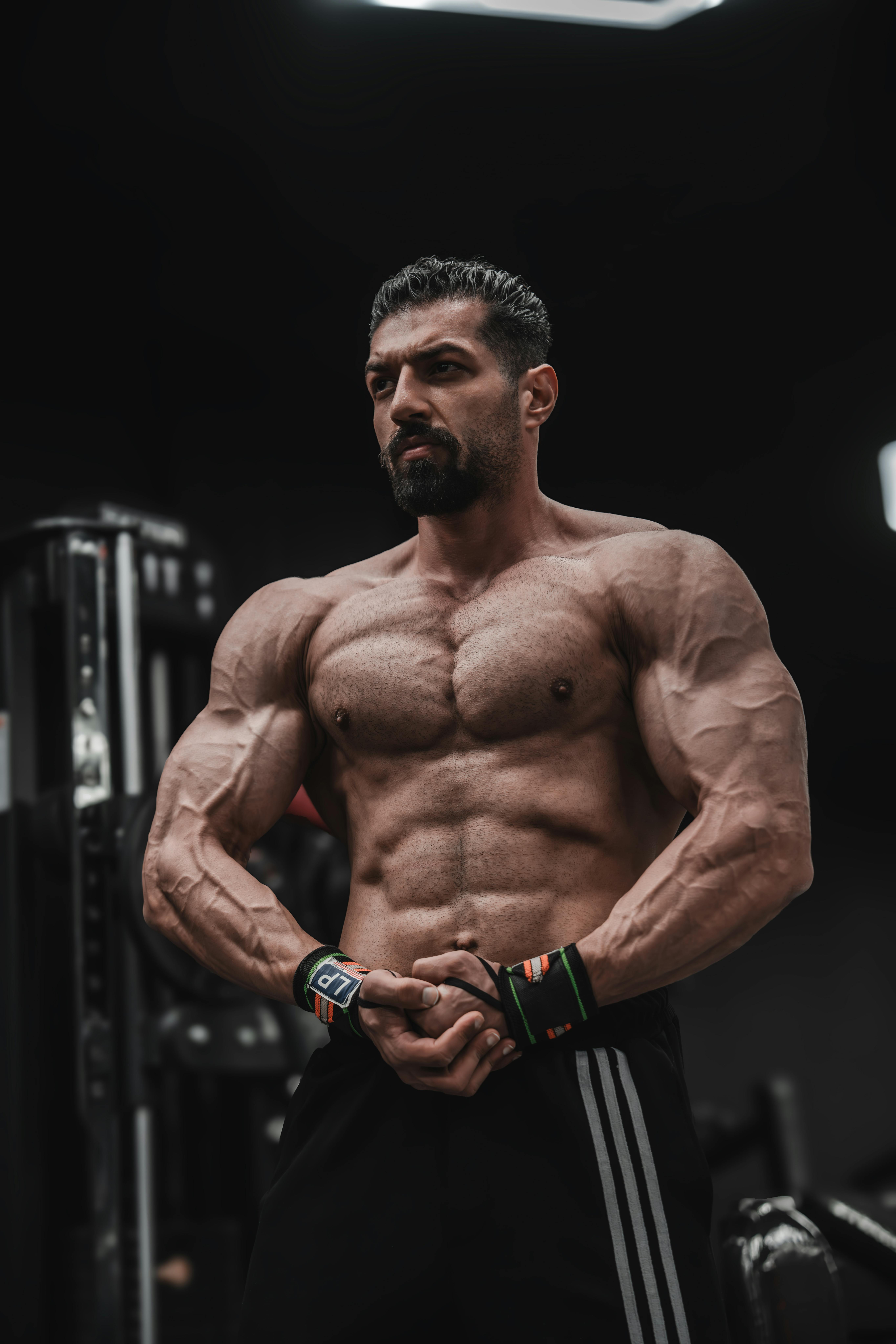 Muscular Man Posing in Gym with Intensity · Free Stock Photo