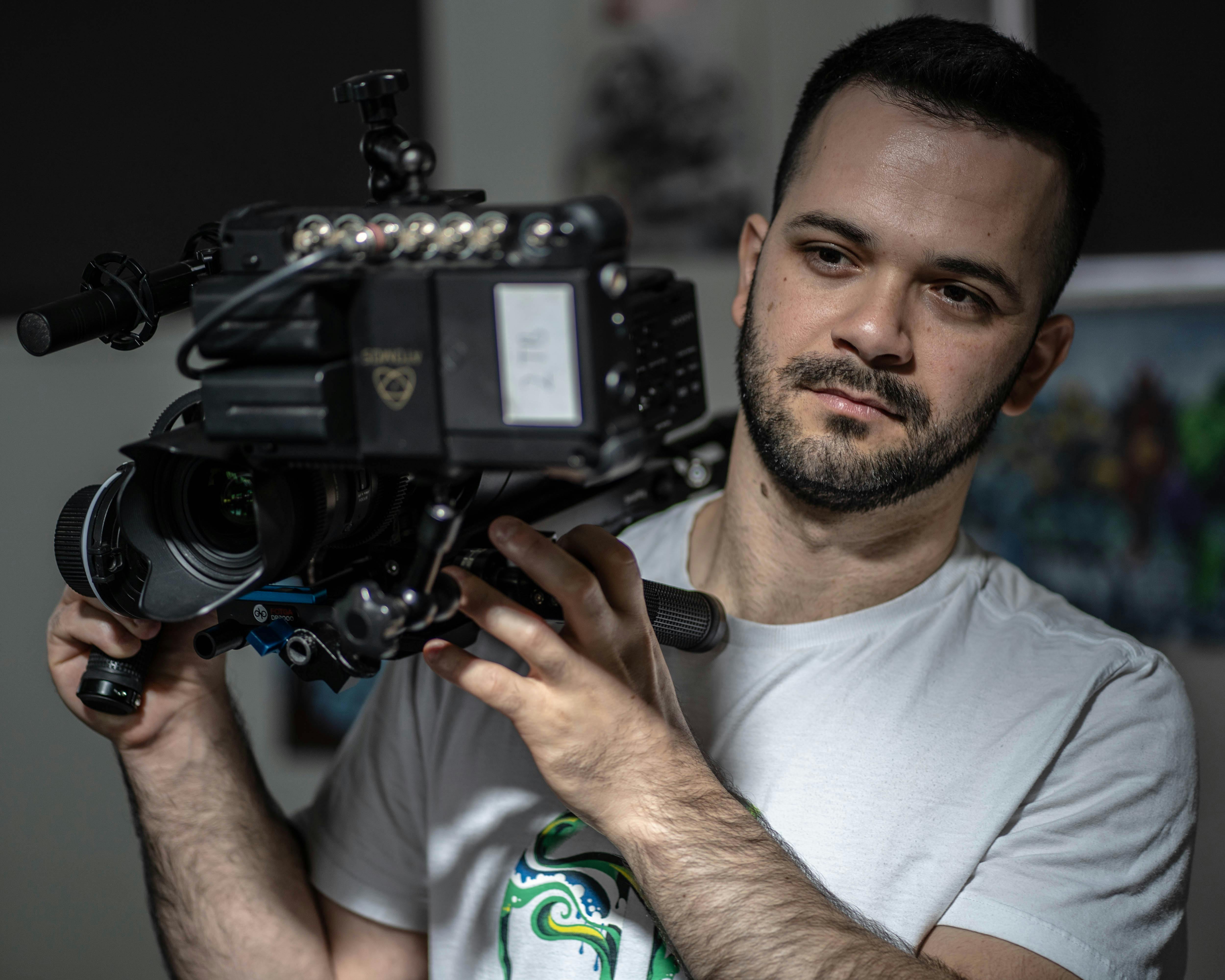 Cameraman Using Professional Video Camera Indoors · Free Stock Photo