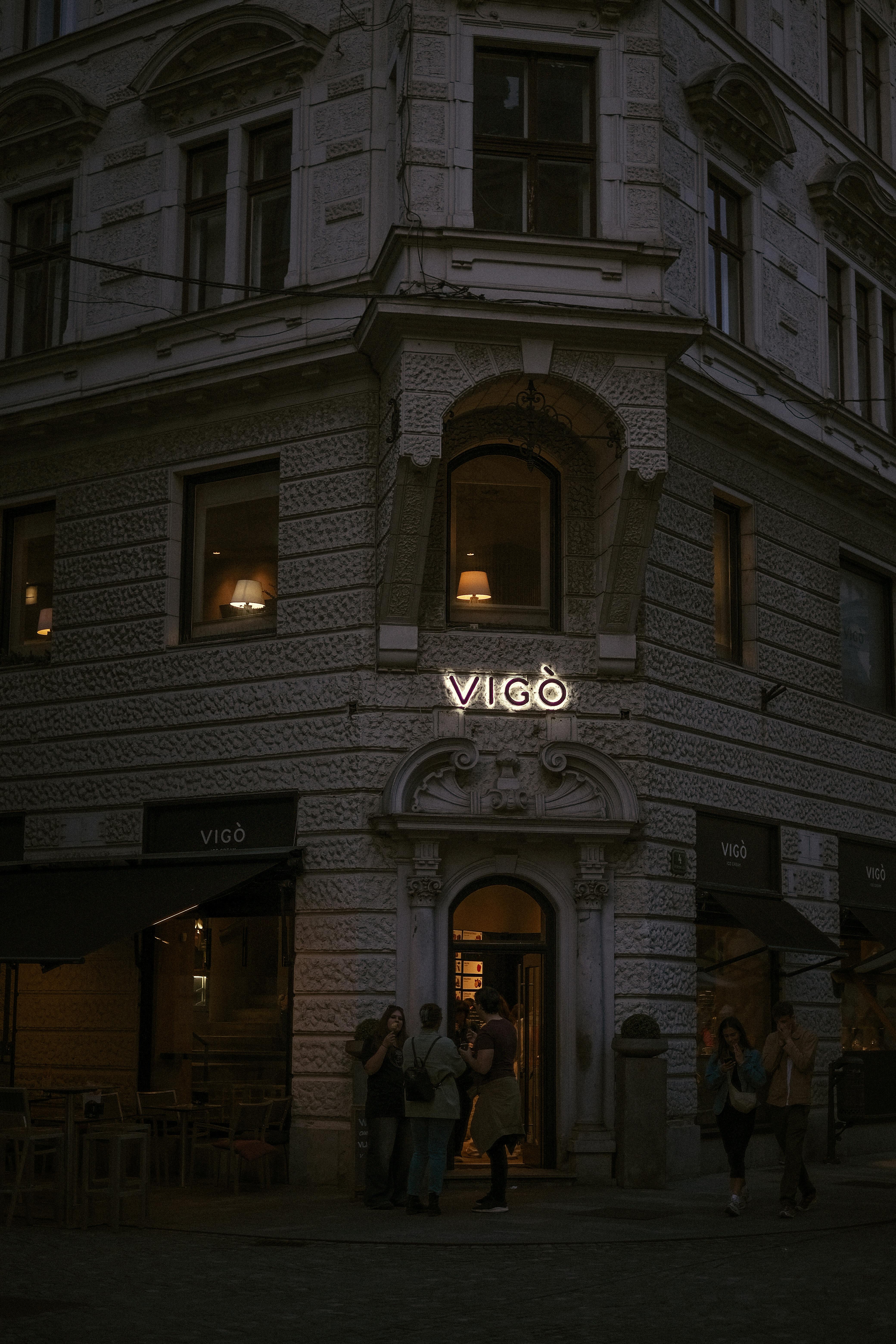 Charming Nighttime Cafe Corner with VIGO Sign · Free Stock Photo