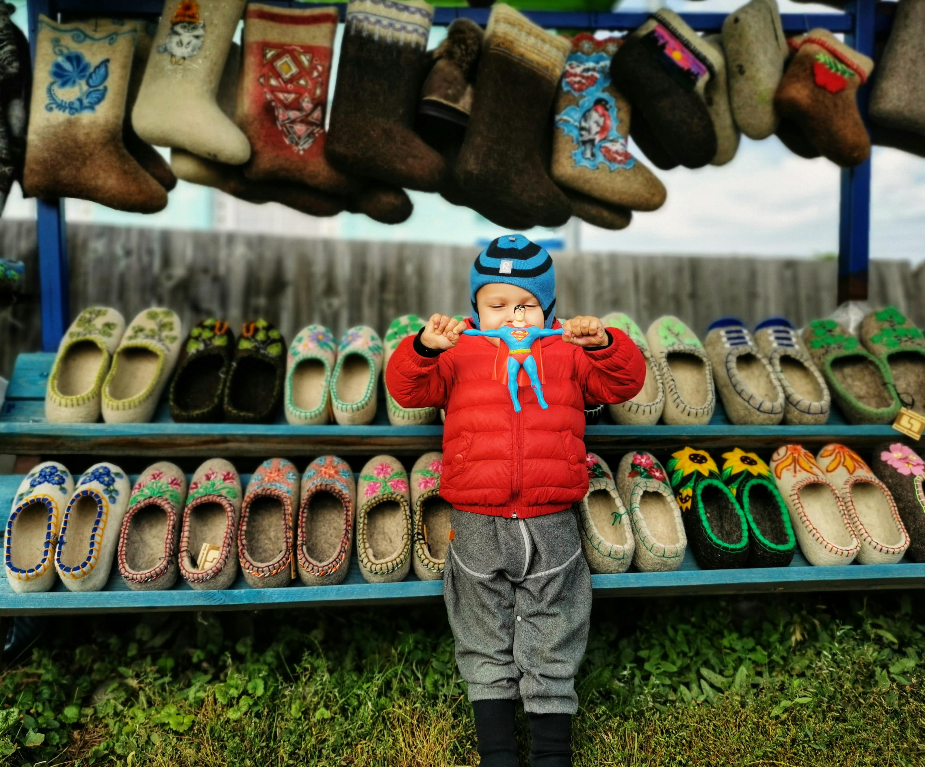 Child in Colorful Outdoor Slipper Market Display · Free Stock Photo