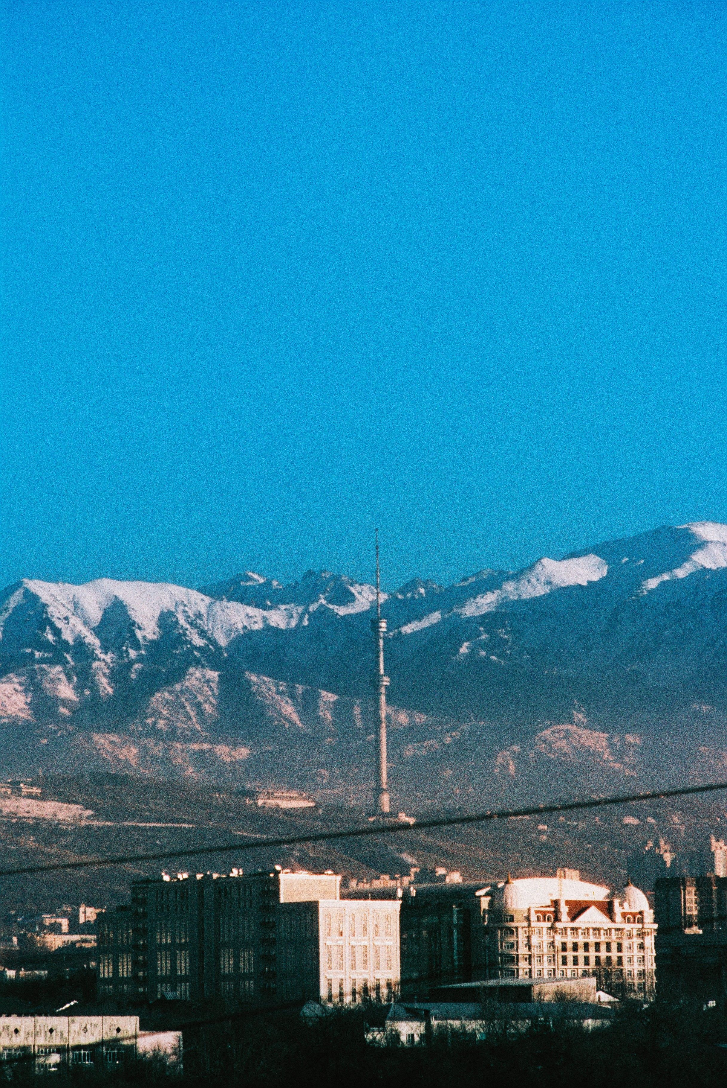 Almaty Cityscape with Mountain Backdrop and Tower · Free Stock Photo