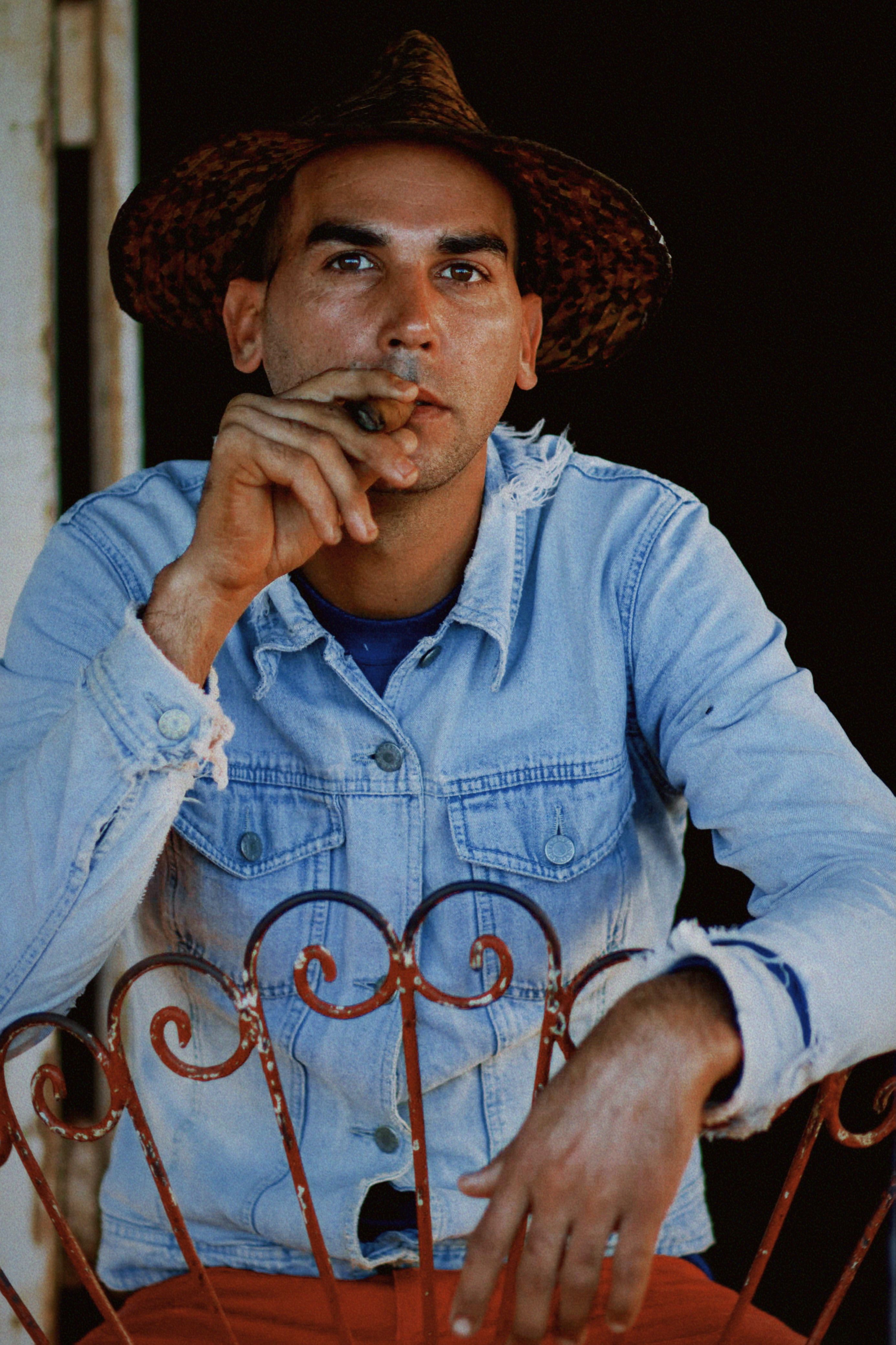 Relaxed Man Smoking Cigar in Denim Jacket · Free Stock Photo