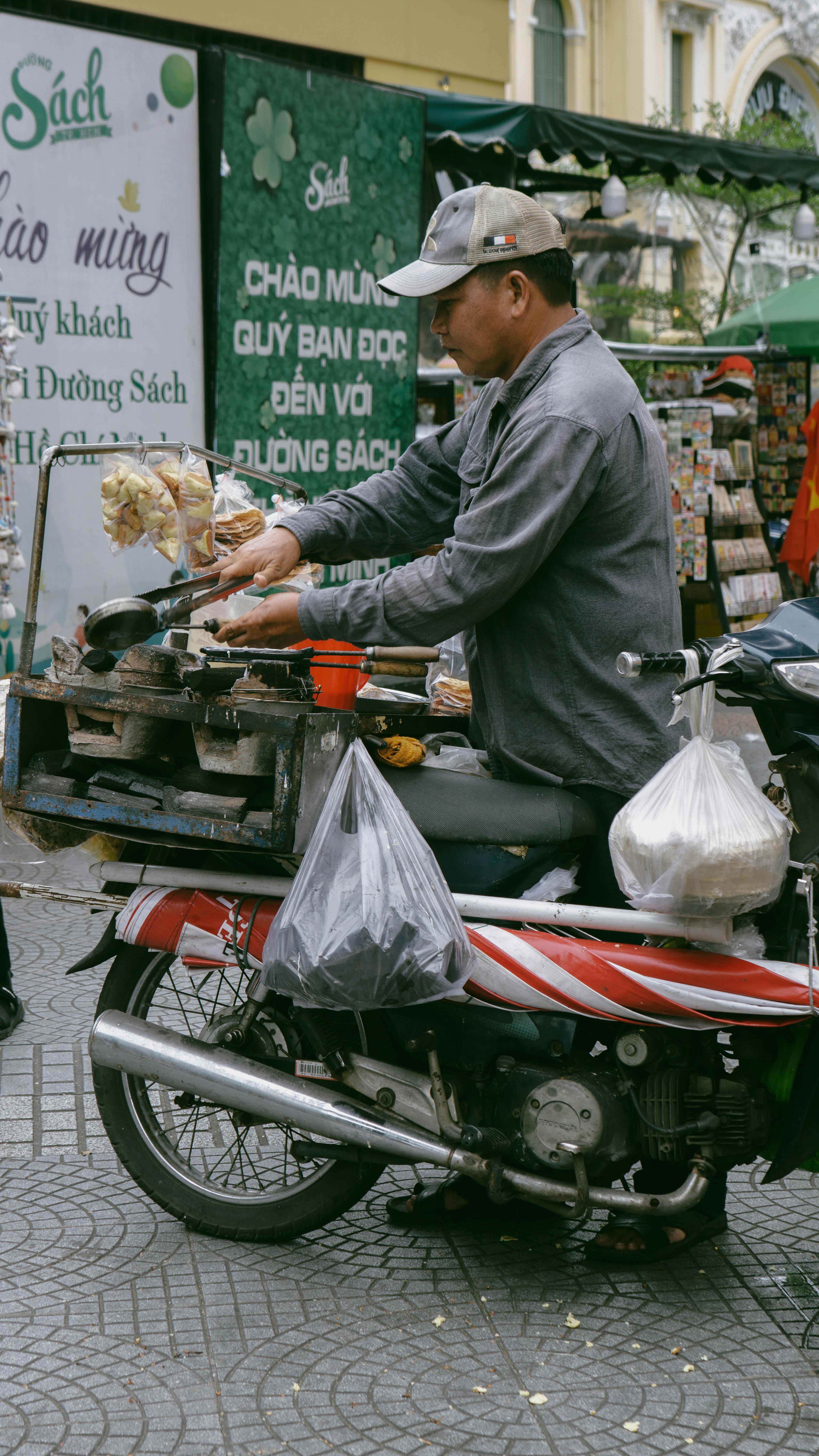 Street Vendor Cooking on Motorcycle in Urban Market · Free Stock Photo