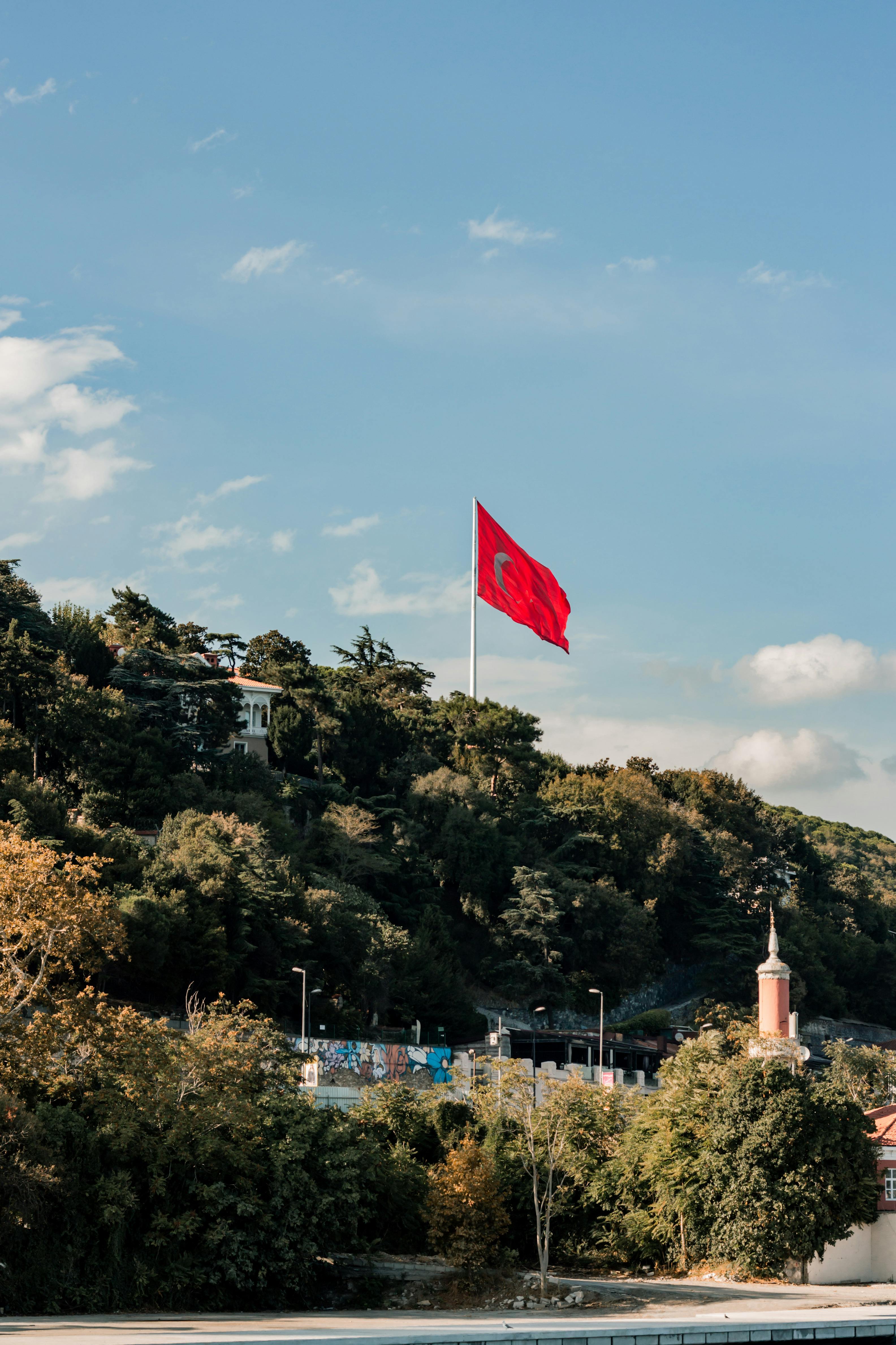 Turkish Flag Waving on Hillside Over Cityscape · Free Stock Photo