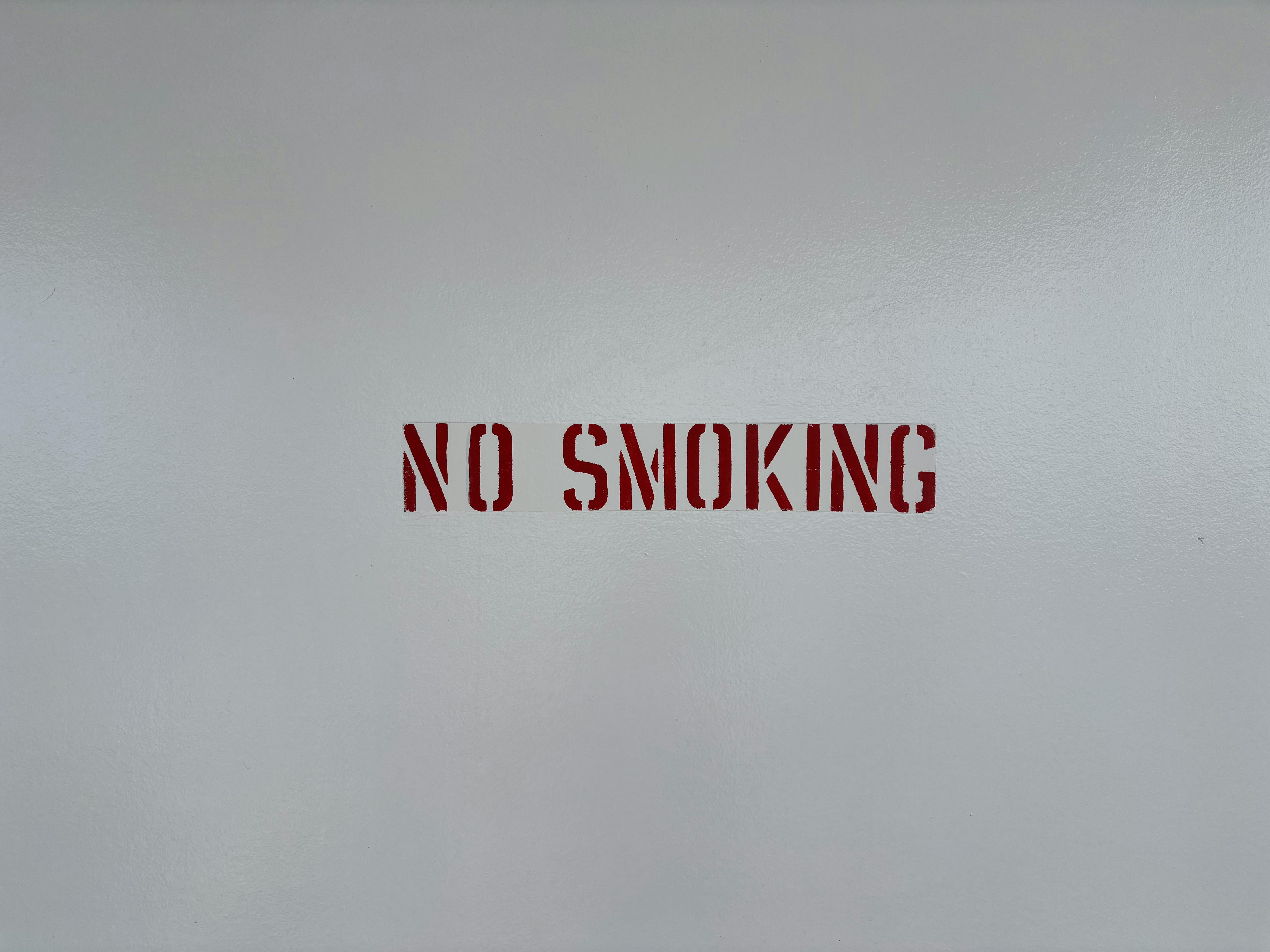 Minimalist No Smoking Sign on Grey Wall · Free Stock Photo