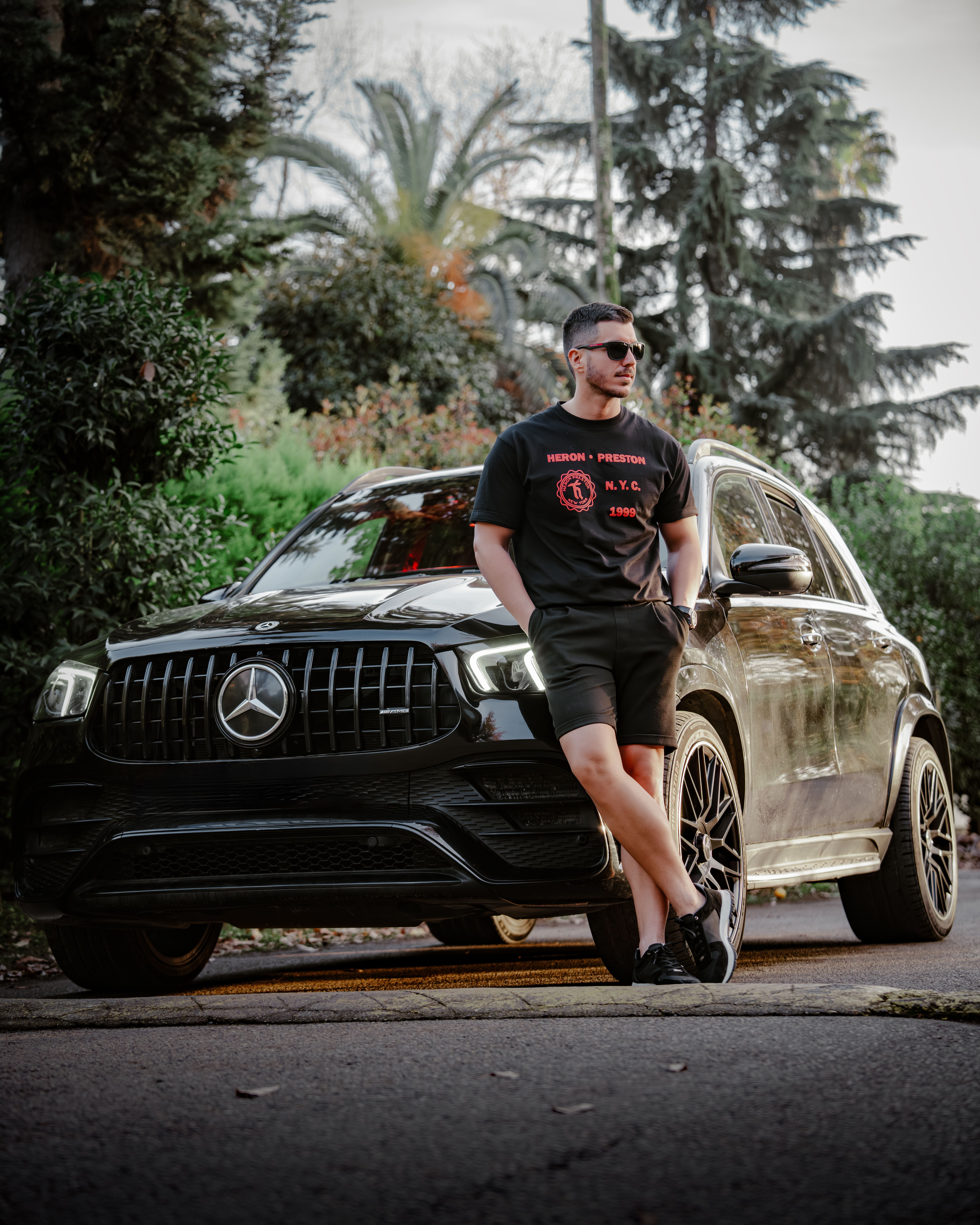 Young Man Leaning on Luxury Black Mercedes SUV · Free Stock Photo