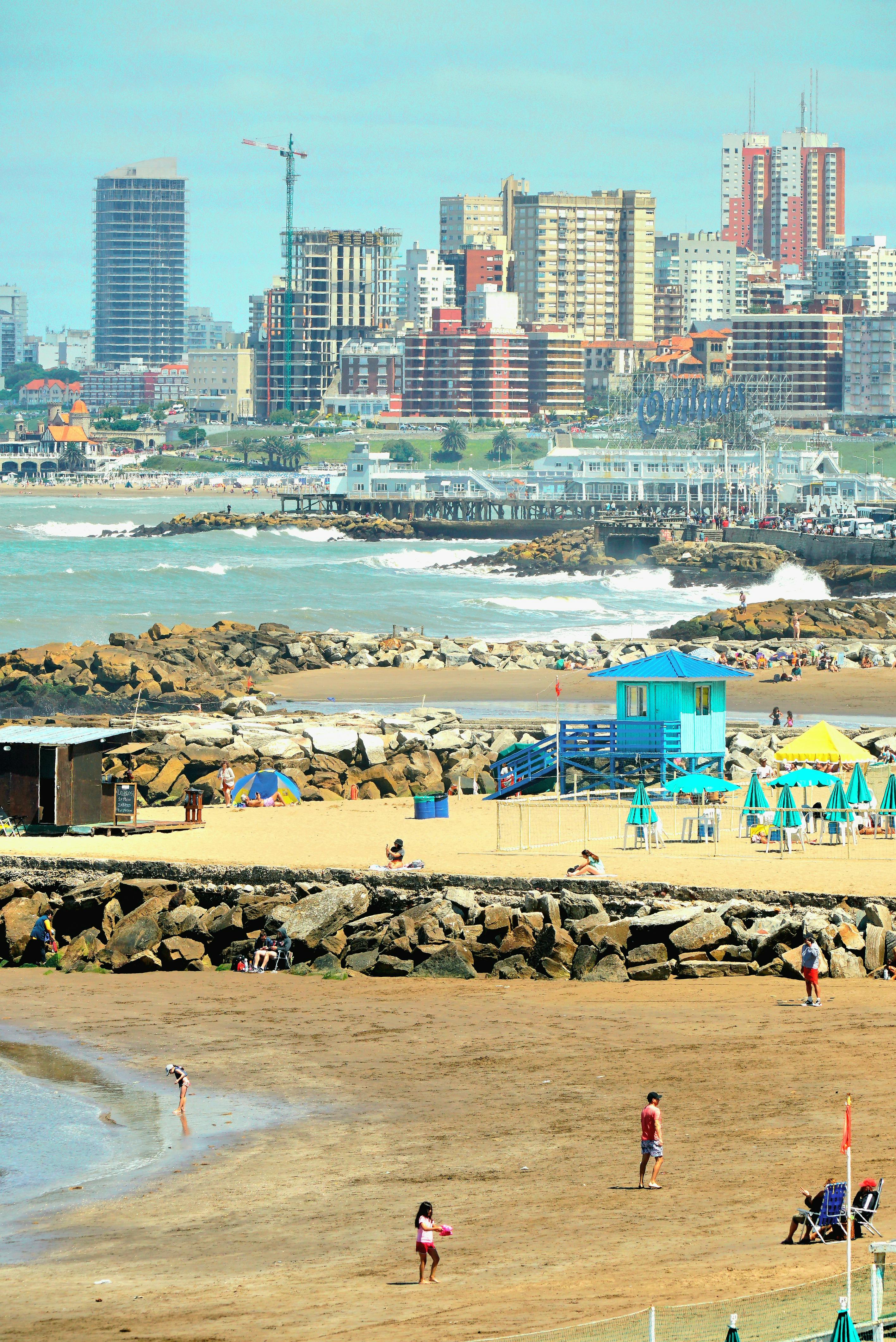 Sunny Beachfront Cityscape with Vibrant Umbrellas · Free Stock Photo