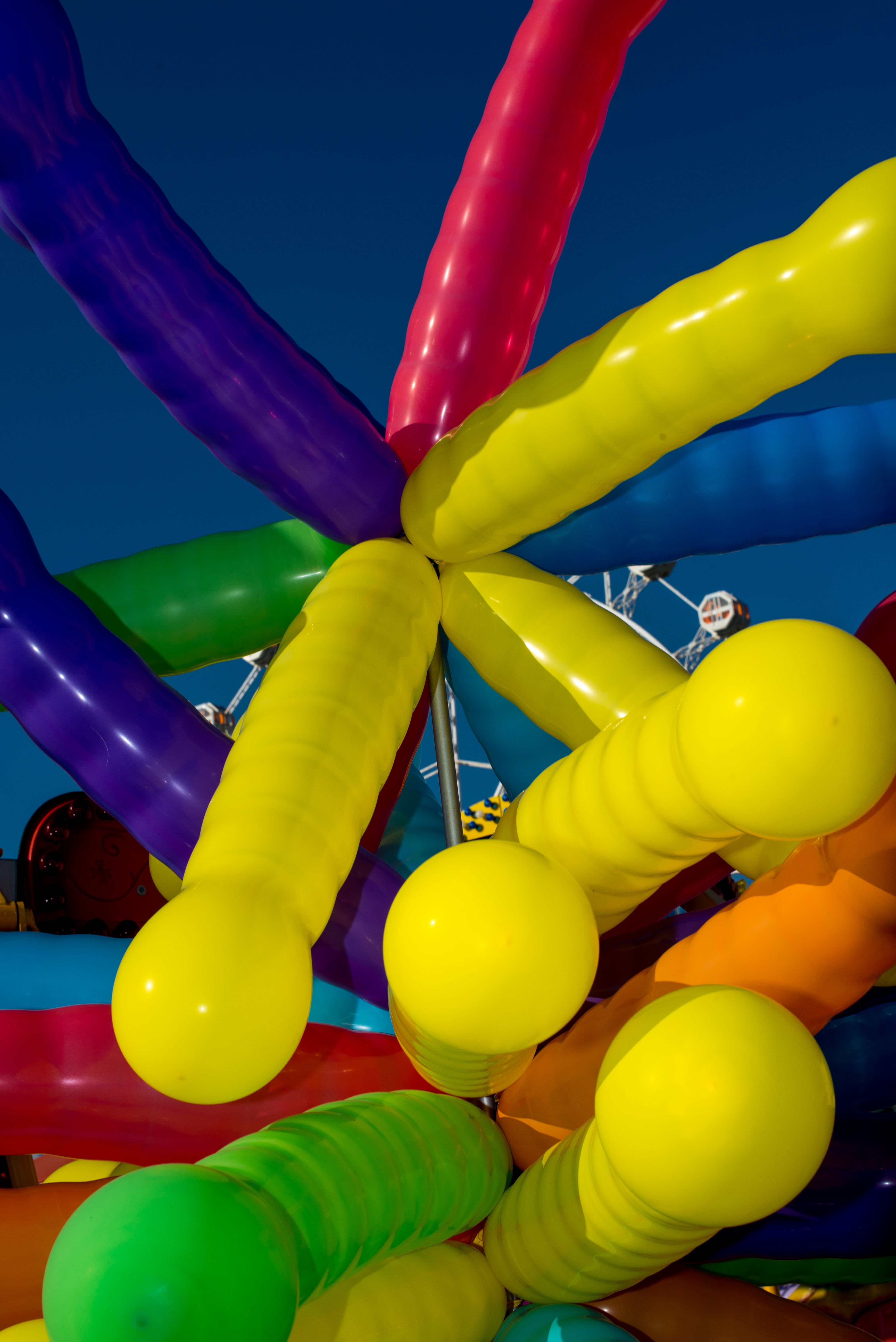 Vibrant Rainbow Balloon Display Against Blue Sky · Free Stock Photo