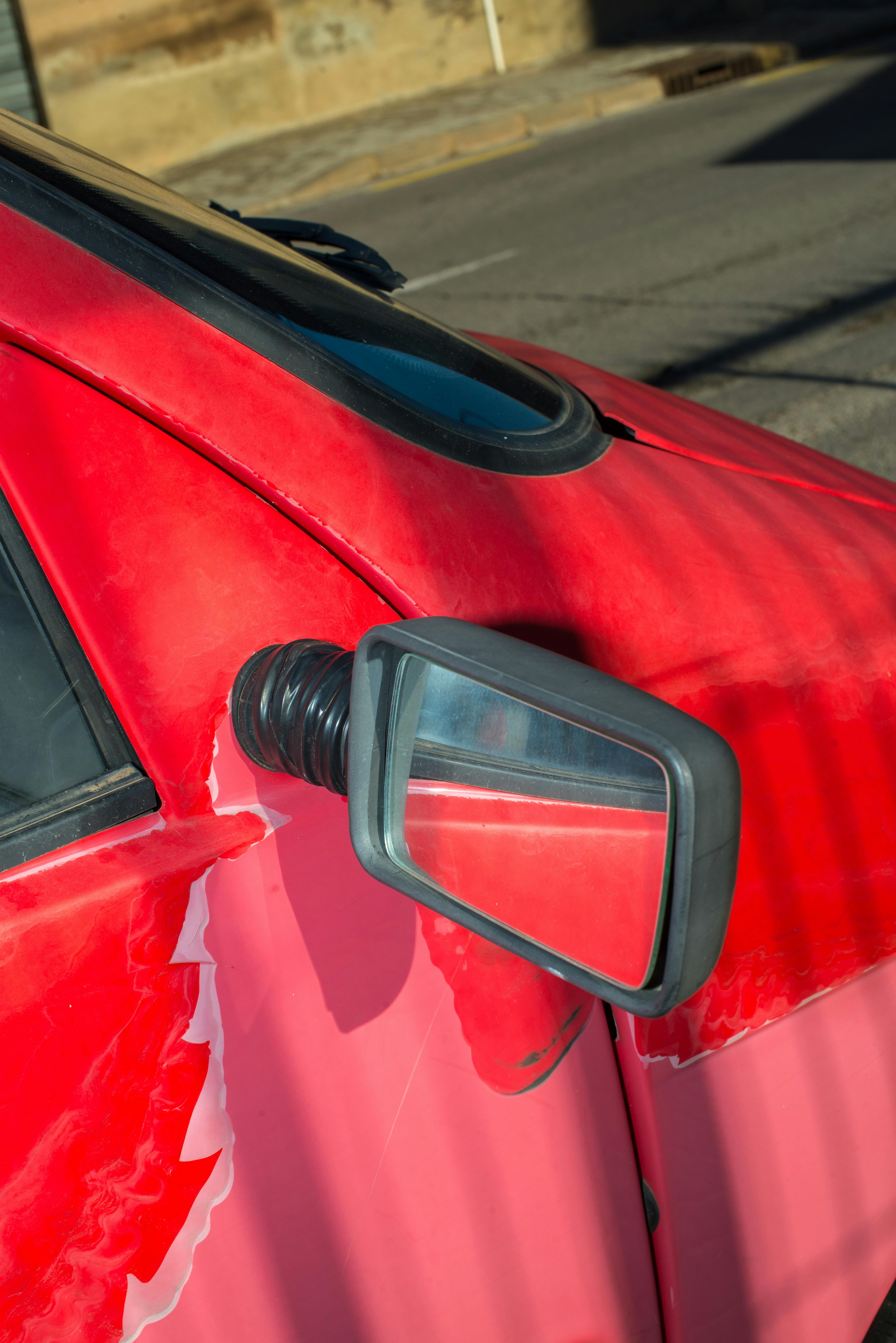 Close-up of Weathered Red Car Mirror · Free Stock Photo