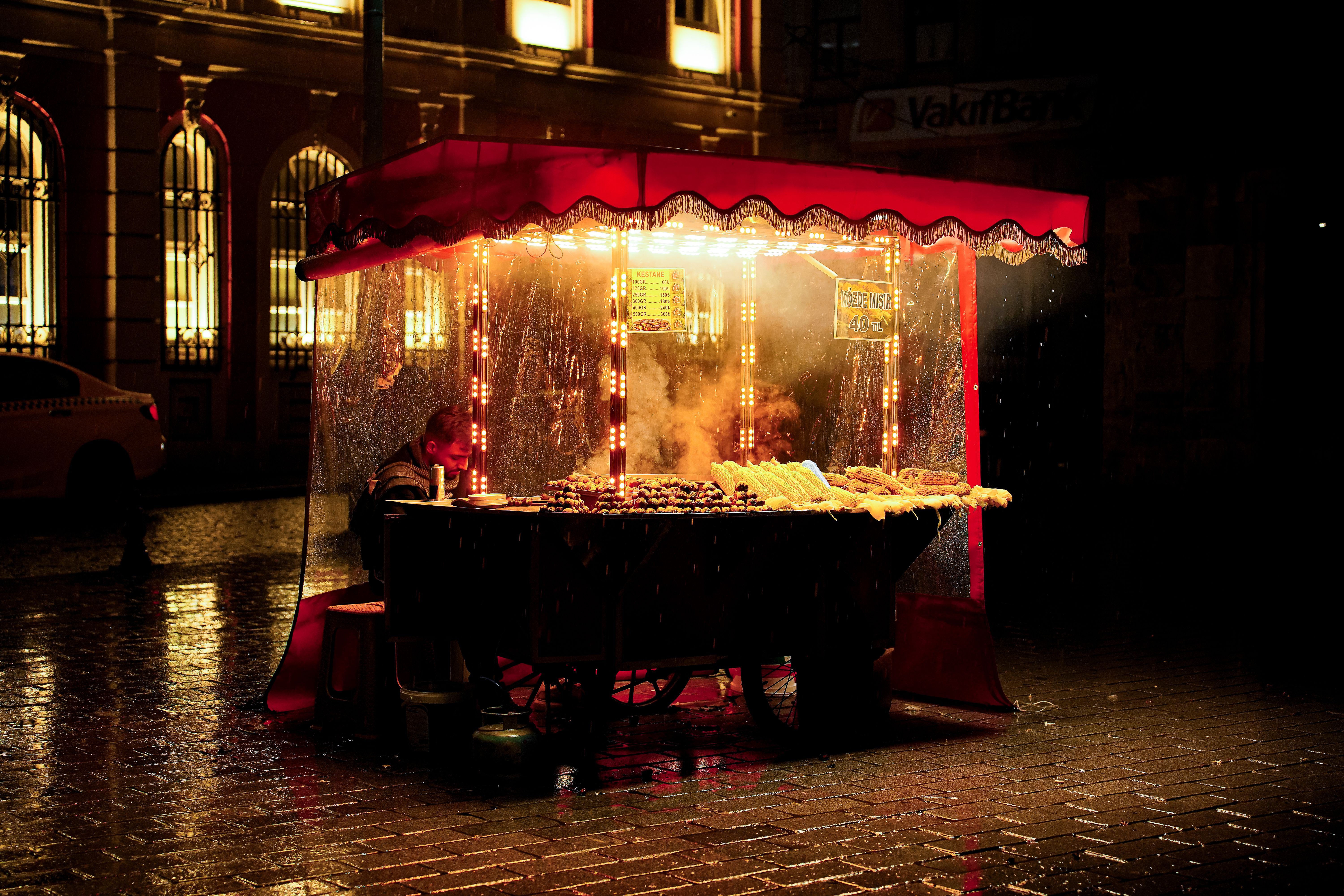 Street Food Vendor at Night During Rain · Free Stock Photo