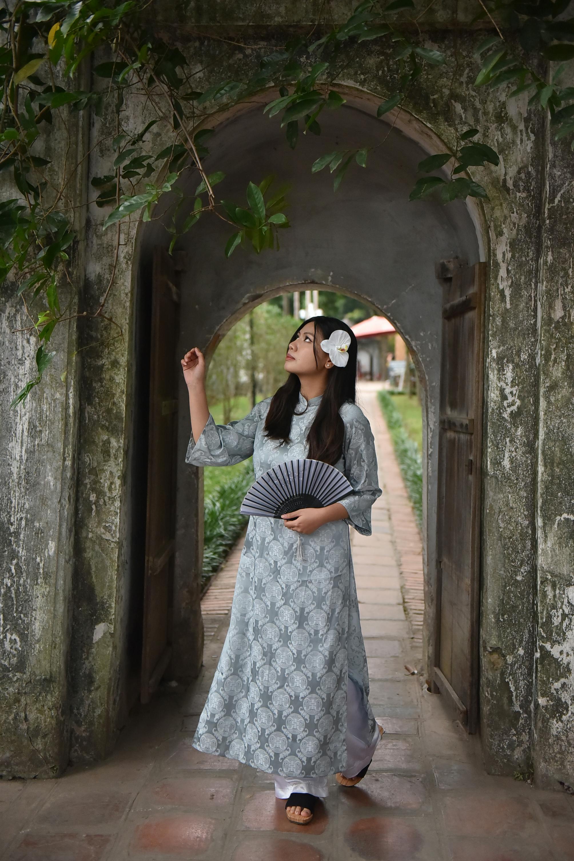 Young Woman in Traditional Dress Walking Through Archway · Free Stock Photo