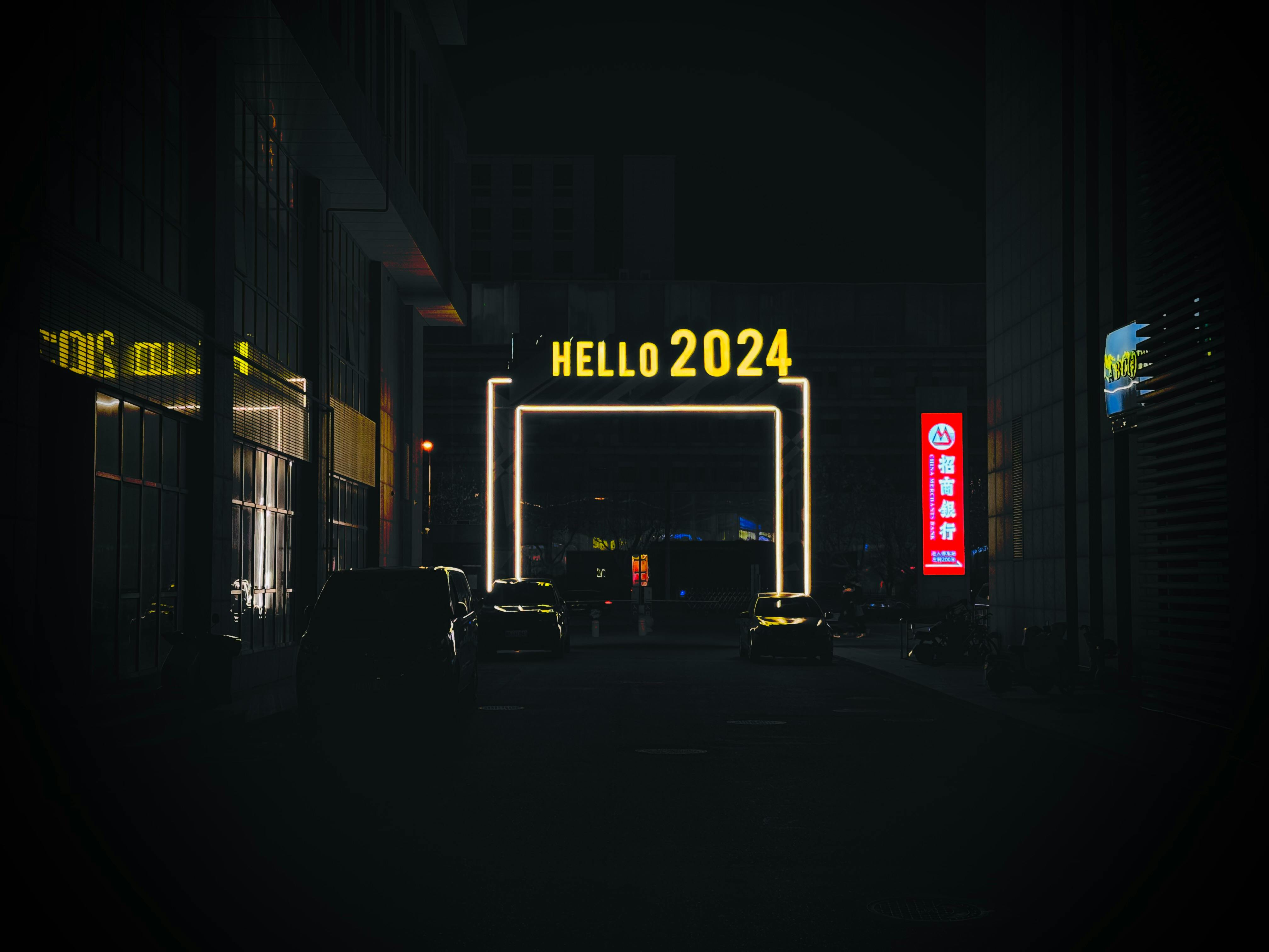 Illuminated City Street at Night with Hello 2024 Sign · Free Stock Photo