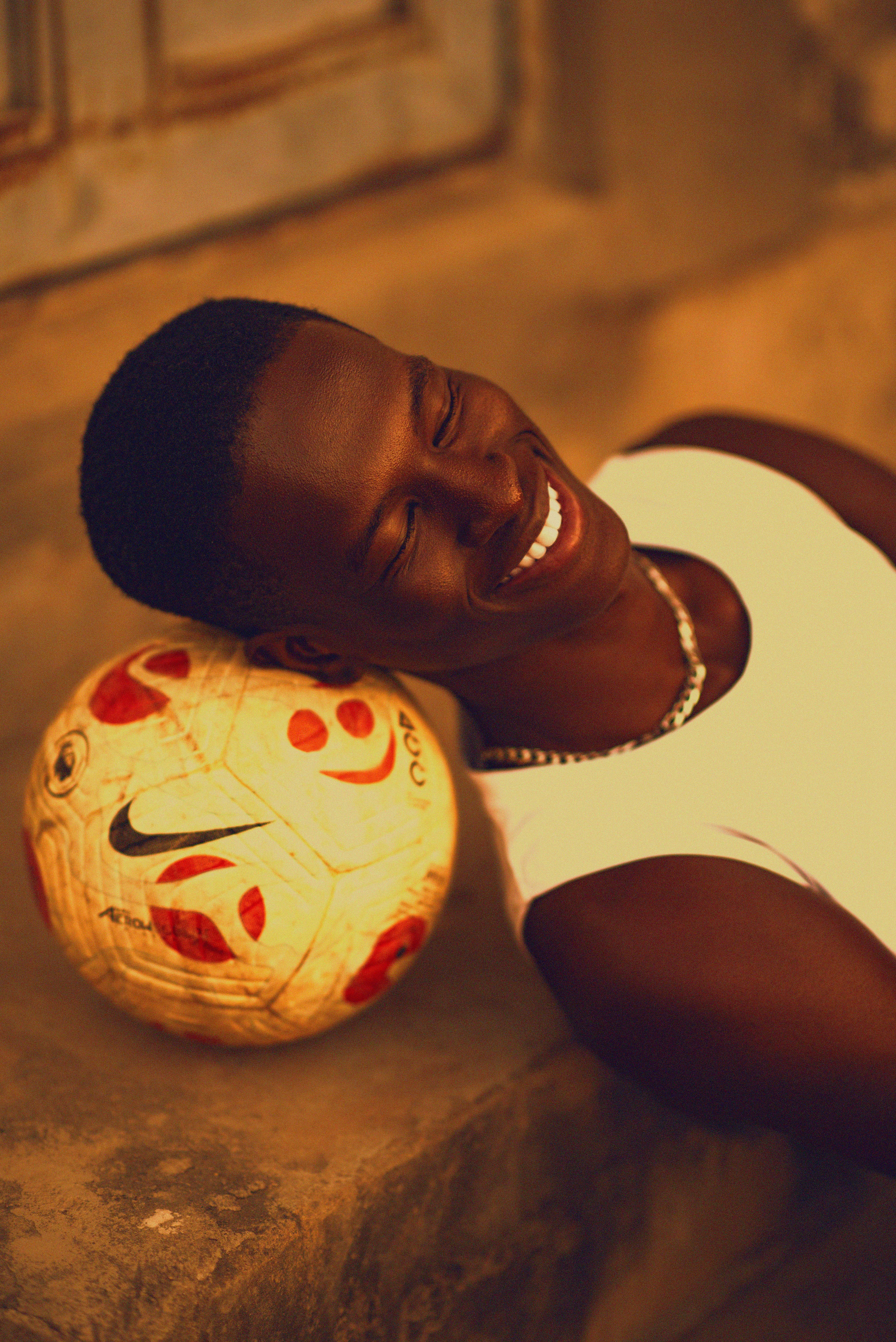 Smiling Man Relaxing with Soccer Ball Outdoors · Free Stock Photo