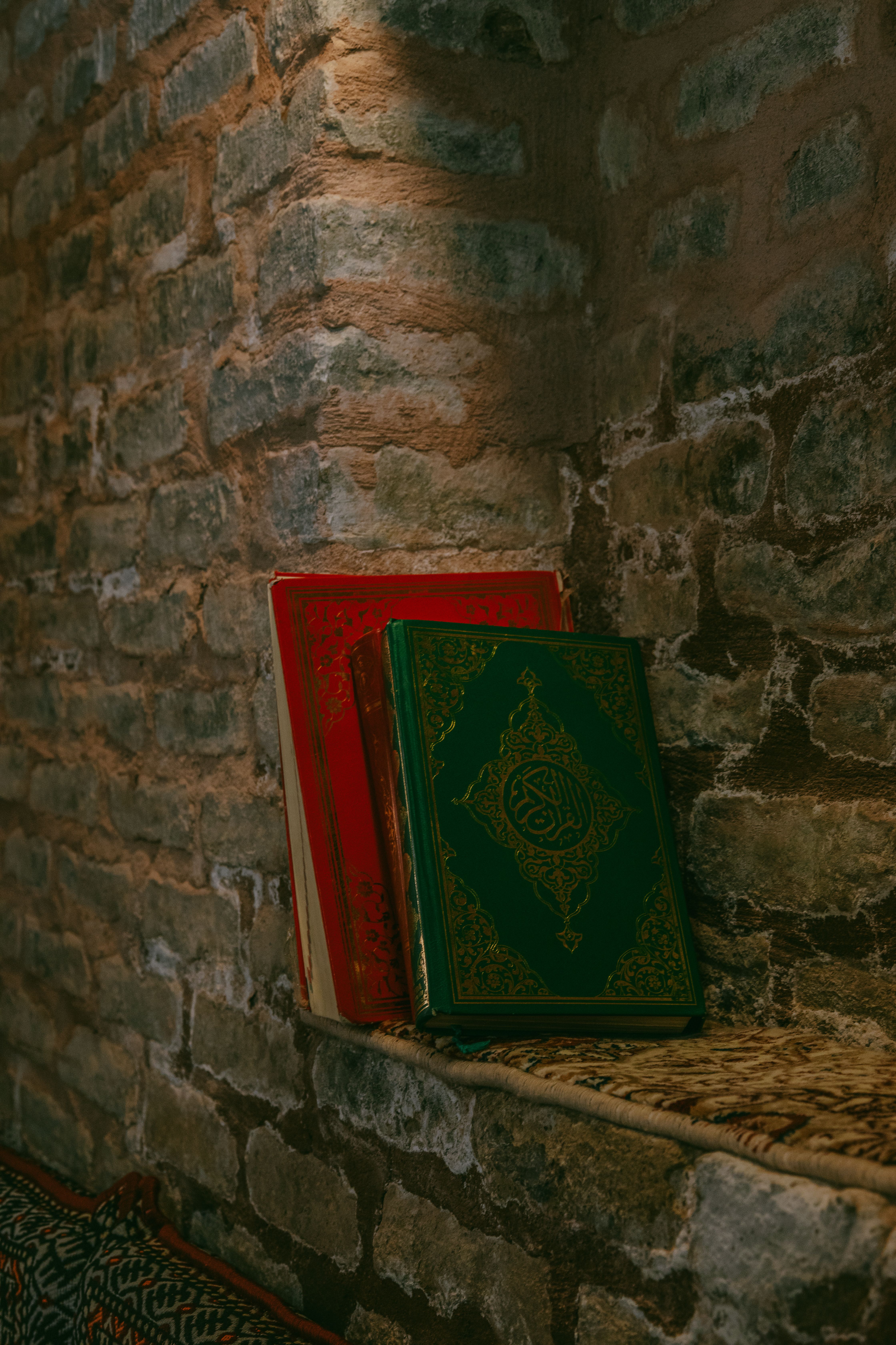 Ancient Books on Stone Wall Shelf · Free Stock Photo