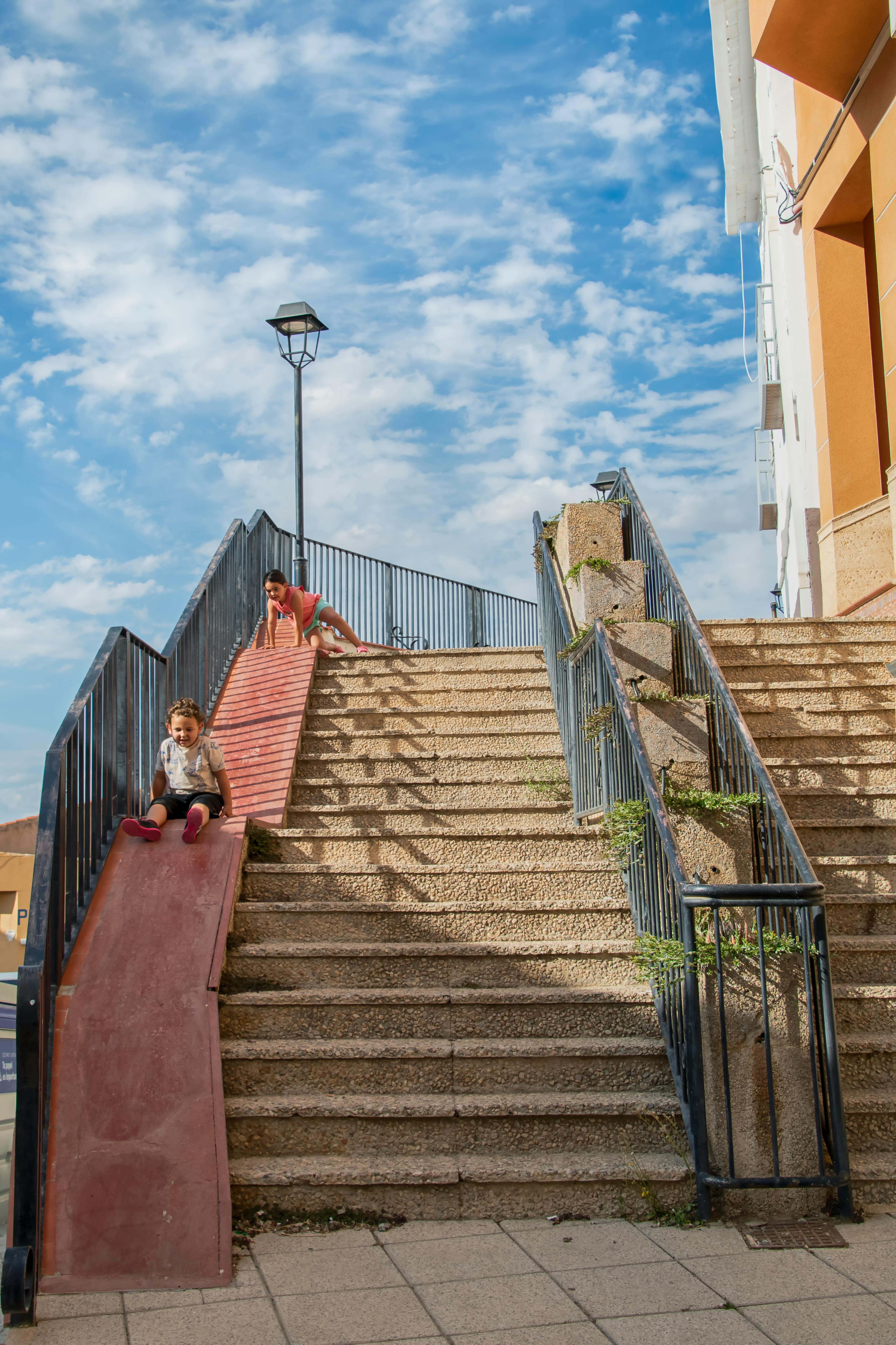 Children Playing on Outdoor Stairs with Slide · Free Stock Photo