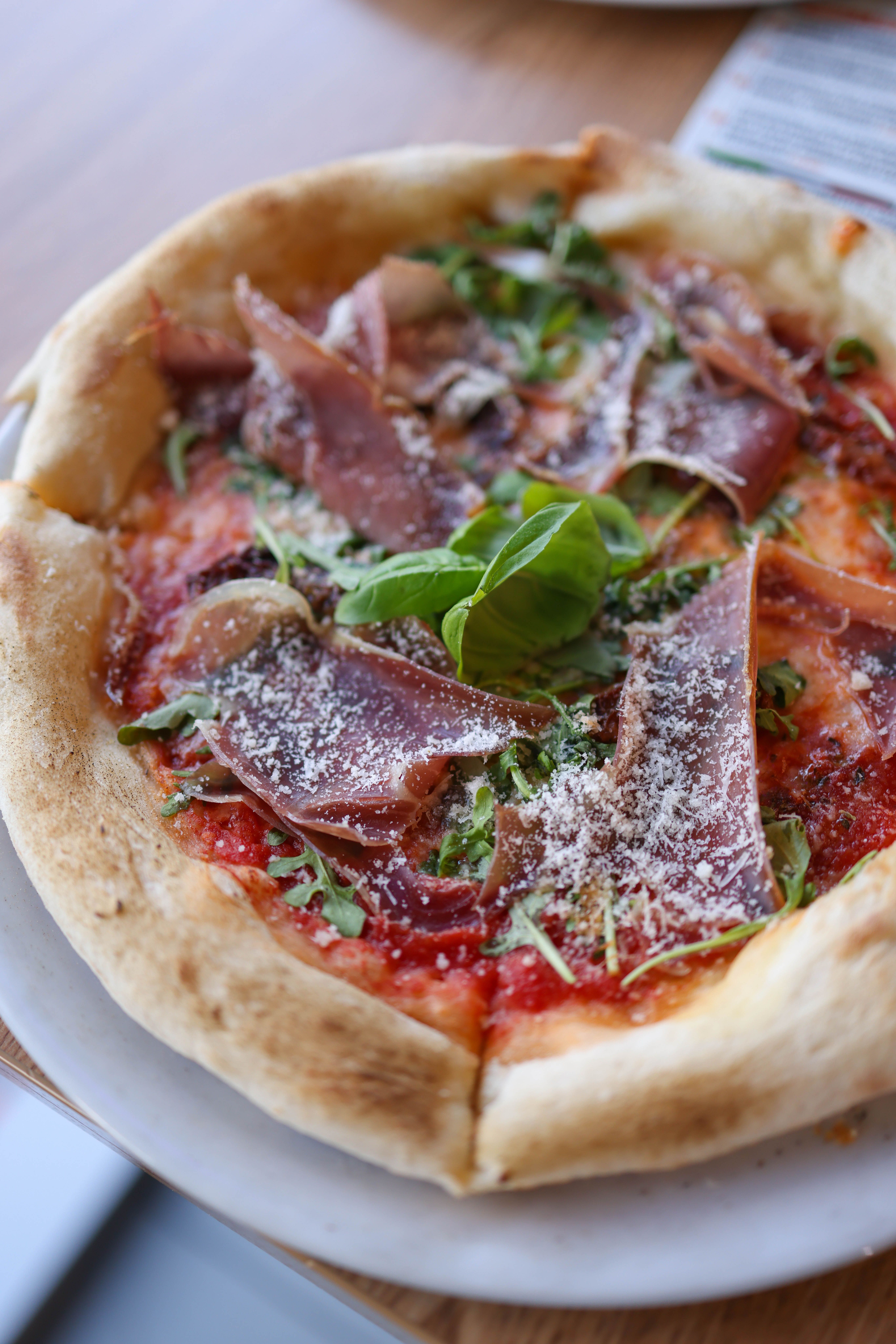 Delicious Italian Pizza with Prosciutto and Arugula · Free Stock Photo