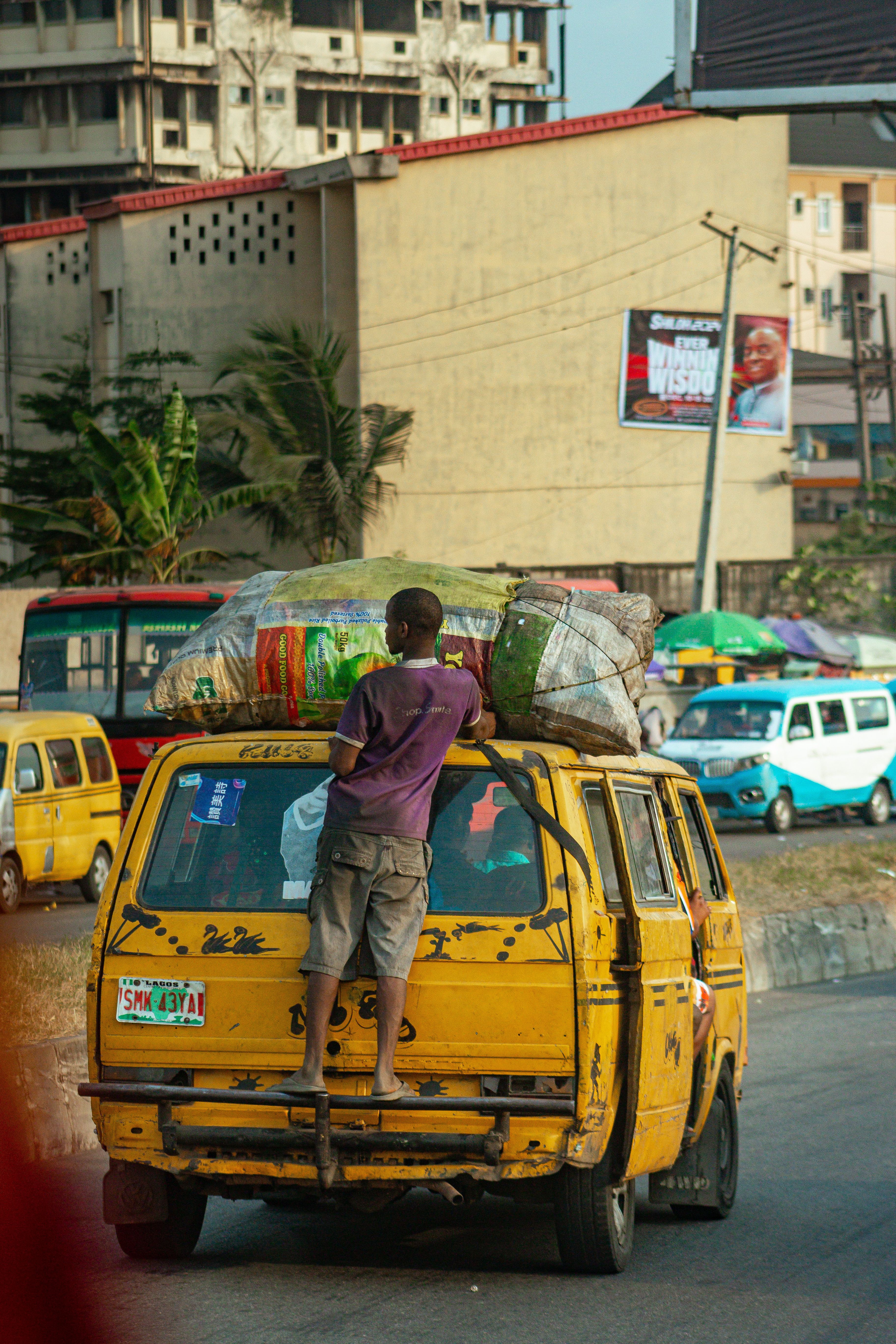 Man Riding a Yellow Bus in Busy Urban Street · Free Stock Photo