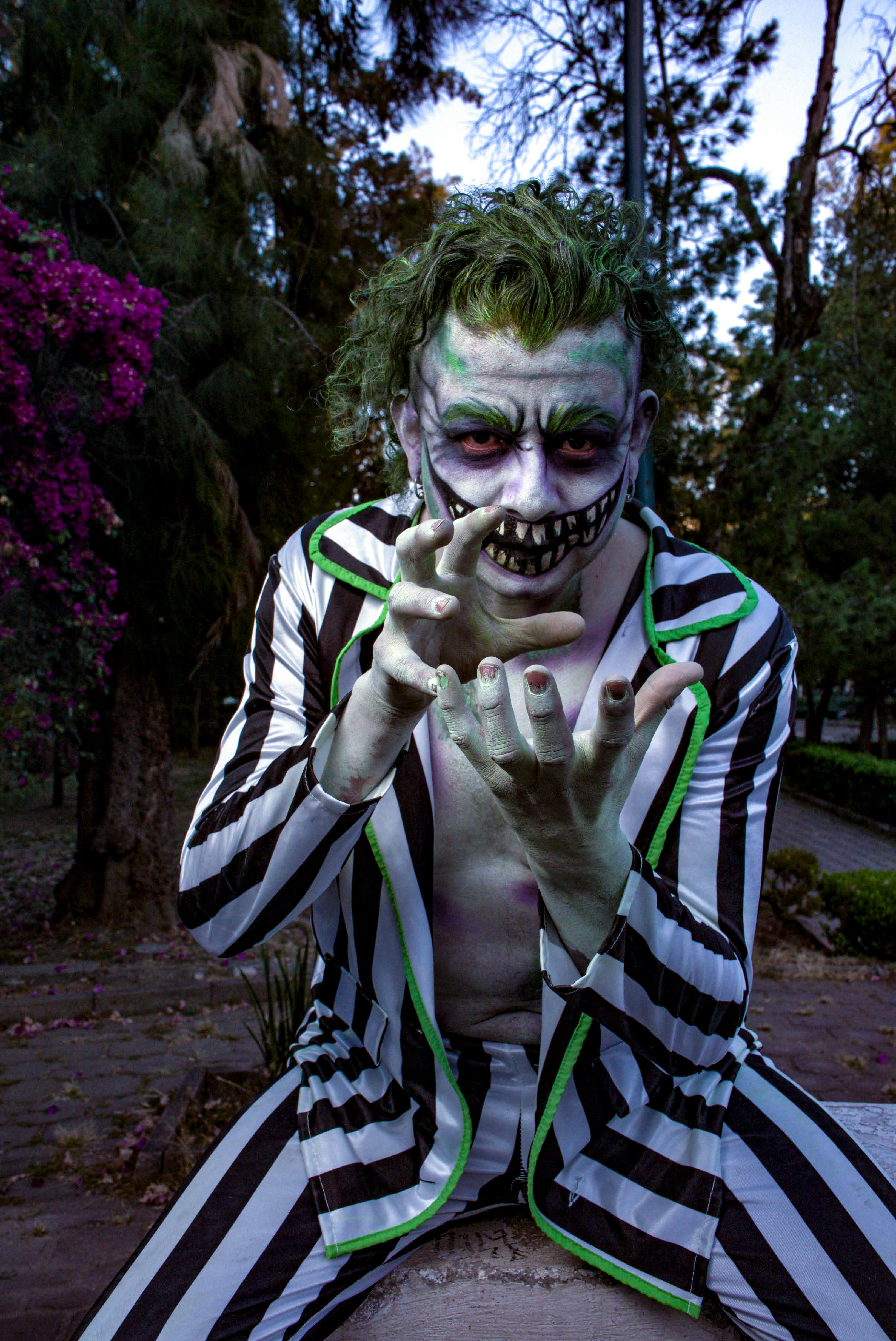 Scary Clown Cosplay in Striped Suit Outdoors · Free Stock Photo