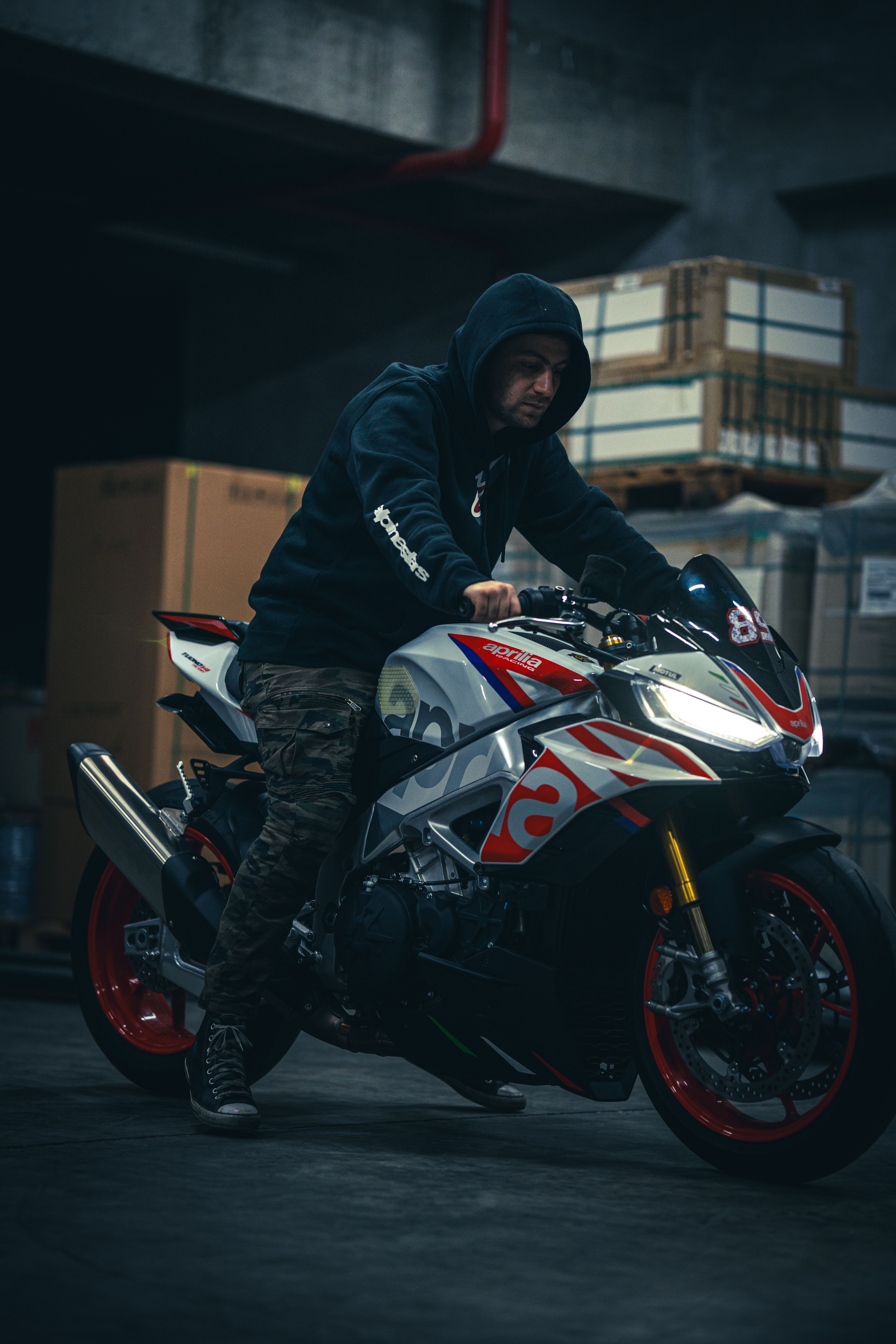 Urban Biker Posing on Sport Motorcycle Indoors · Free Stock Photo