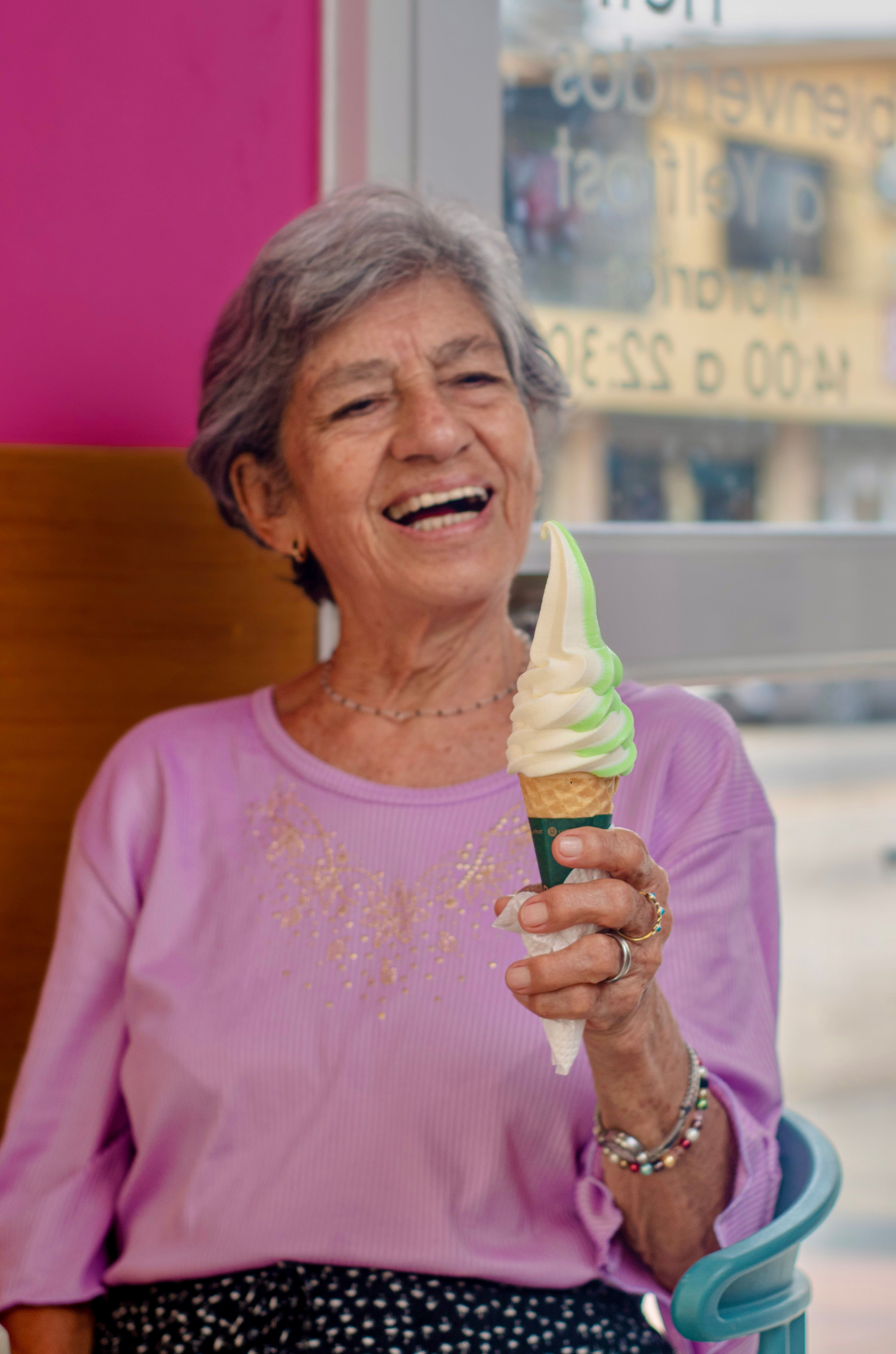 Joyful senior woman enjoying ice cream indoors · Free Stock Photo