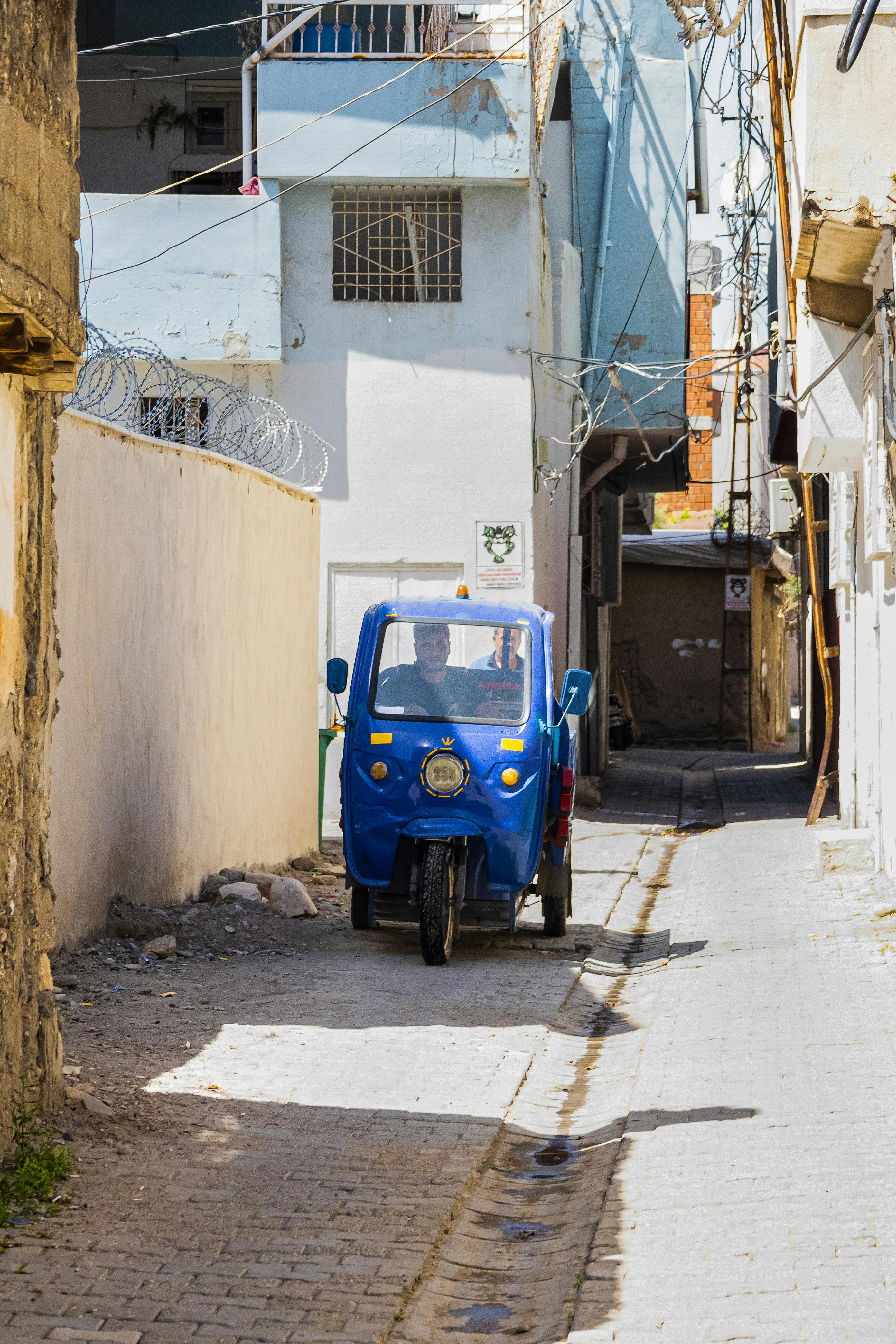 Blue Motorized Rickshaw in Narrow Urban Alleyway · Free Stock Photo