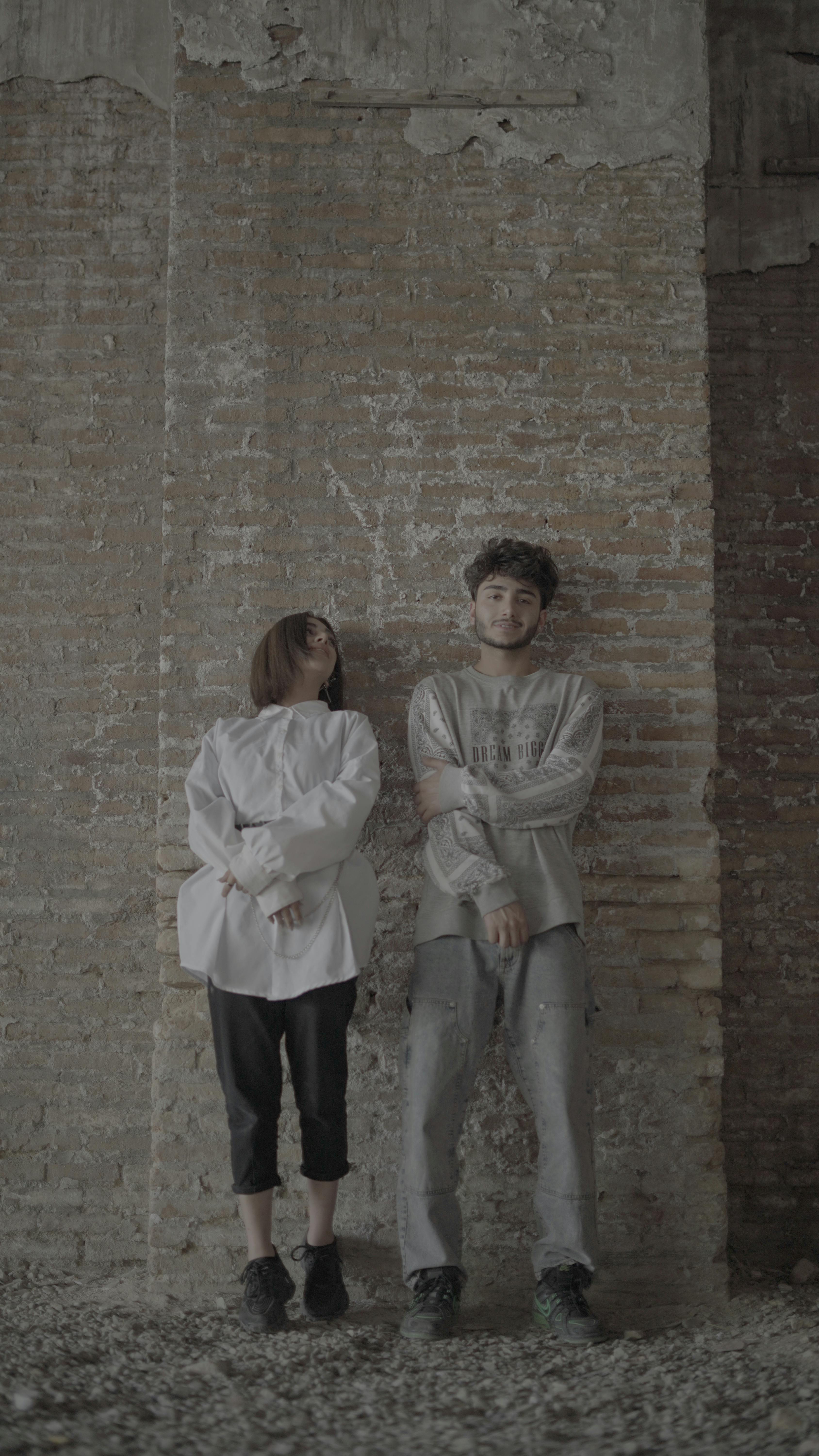 Urban Portrait of Two People Against Brick Wall · Free Stock Photo