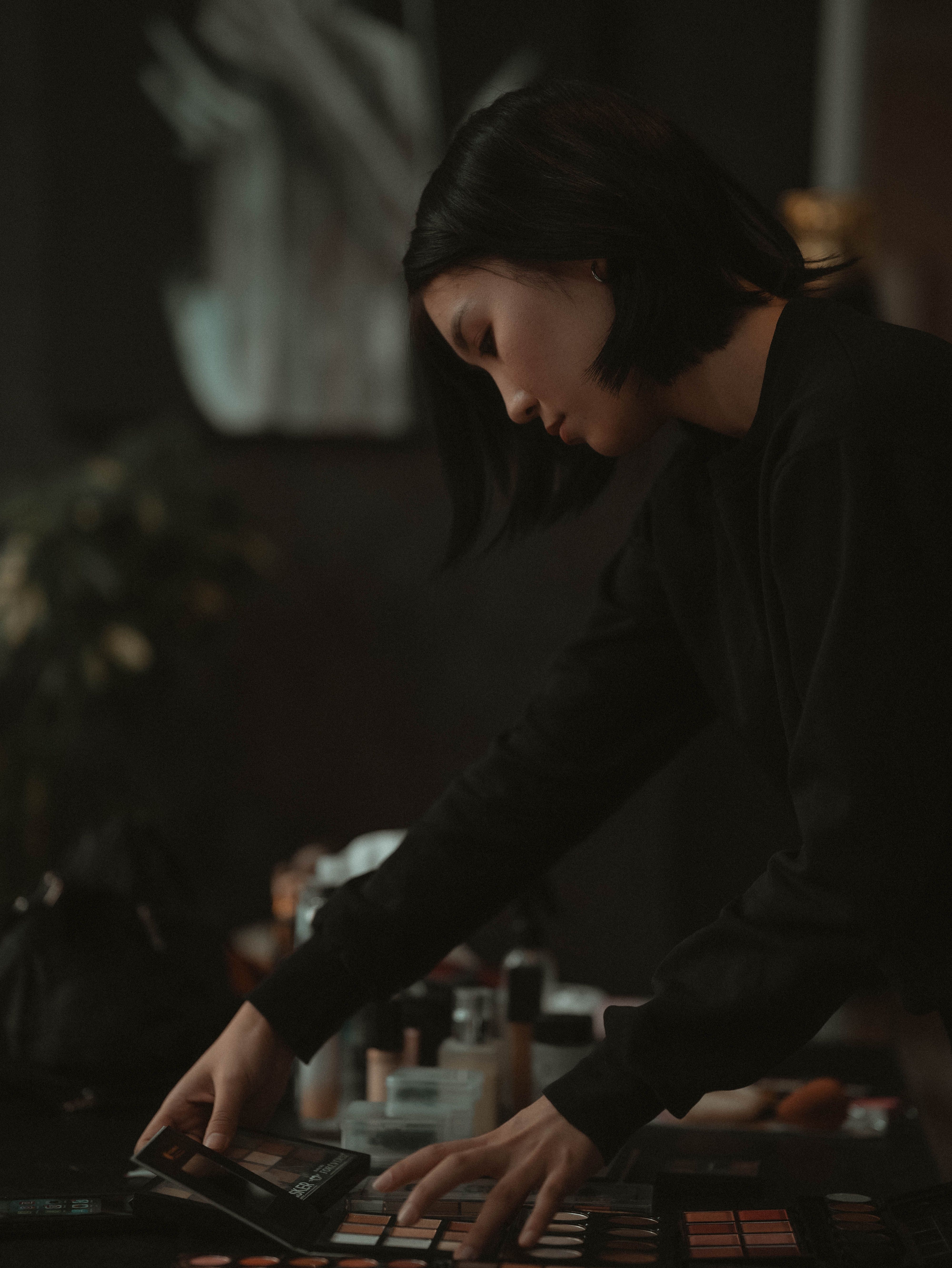 Young Woman Applying Makeup Indoors · Free Stock Photo