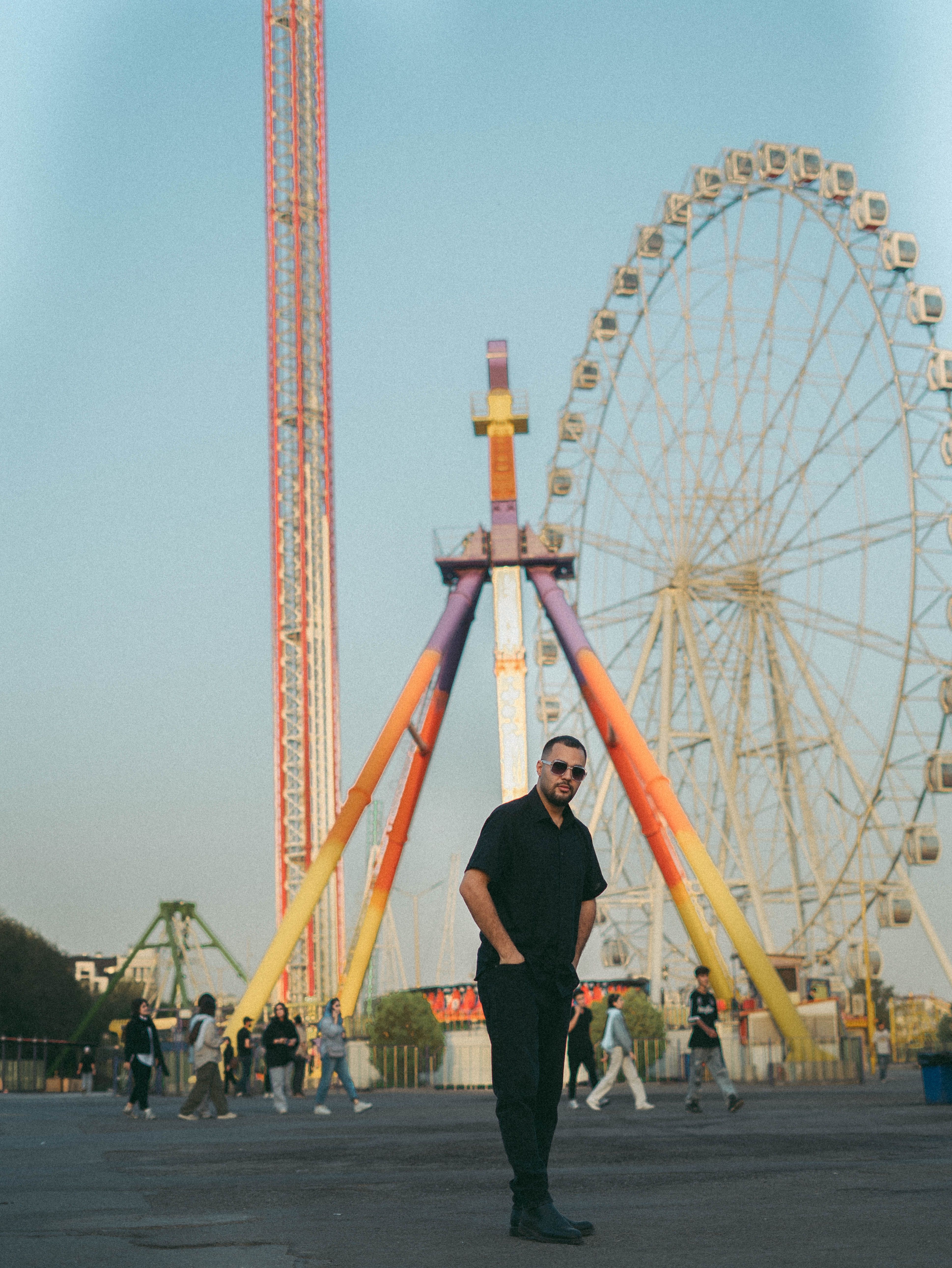 Man Standing in Front of Colorful Ferris Wheel · Free Stock Photo