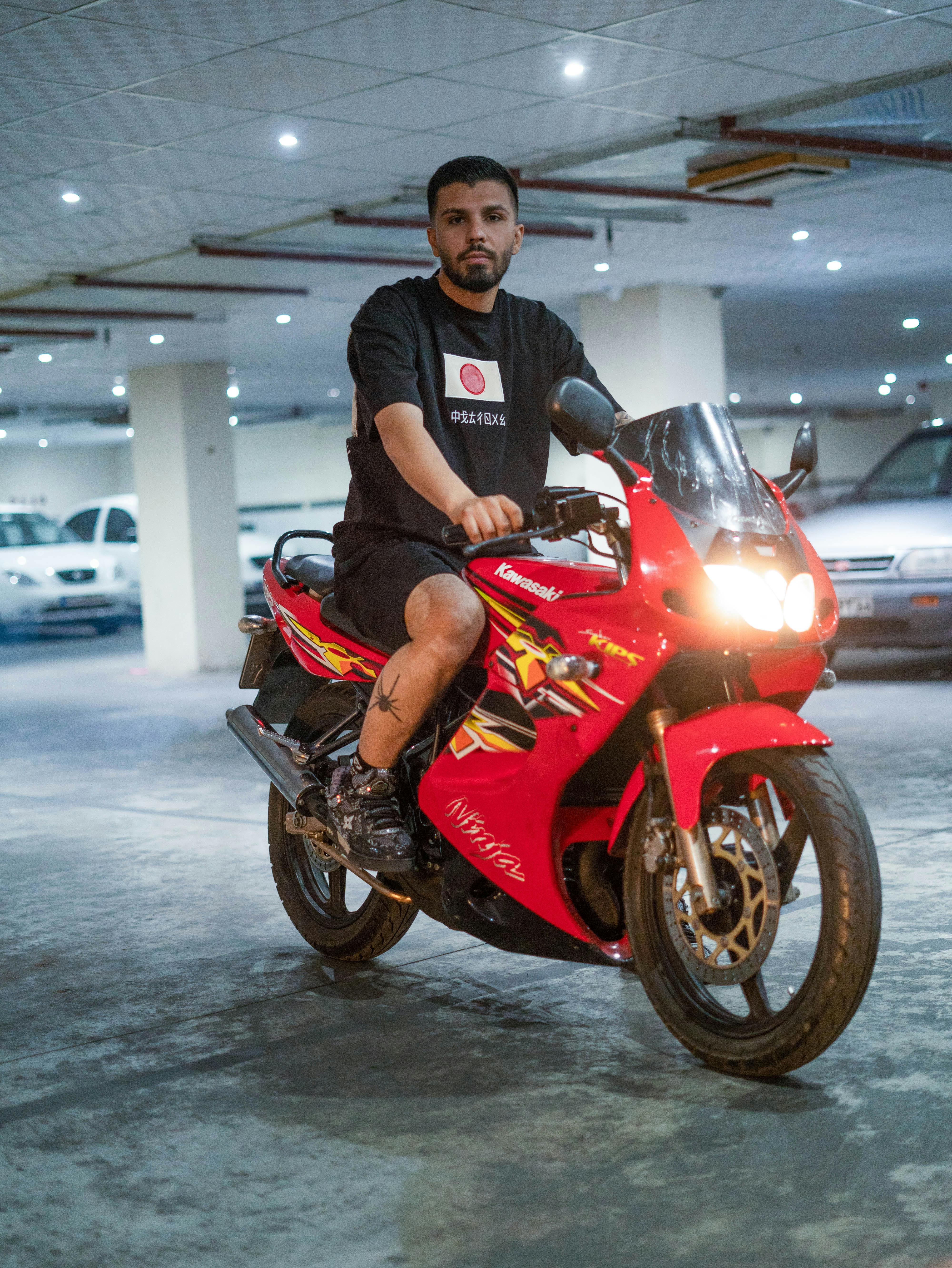 Man Riding Red Motorcycle in Parking Garage · Free Stock Photo
