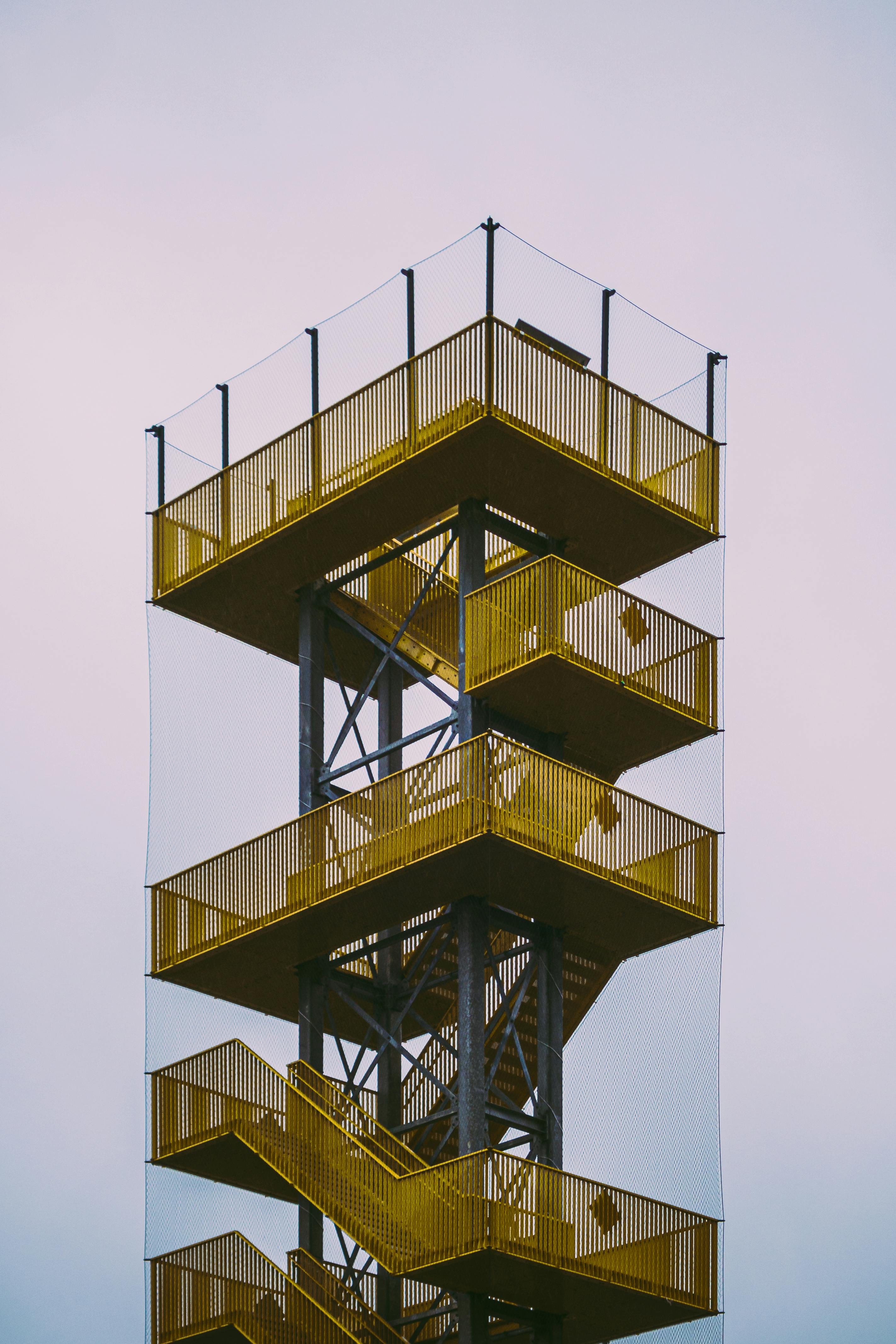Modern Yellow Observation Tower Against Cloudy Sky · Free Stock Photo