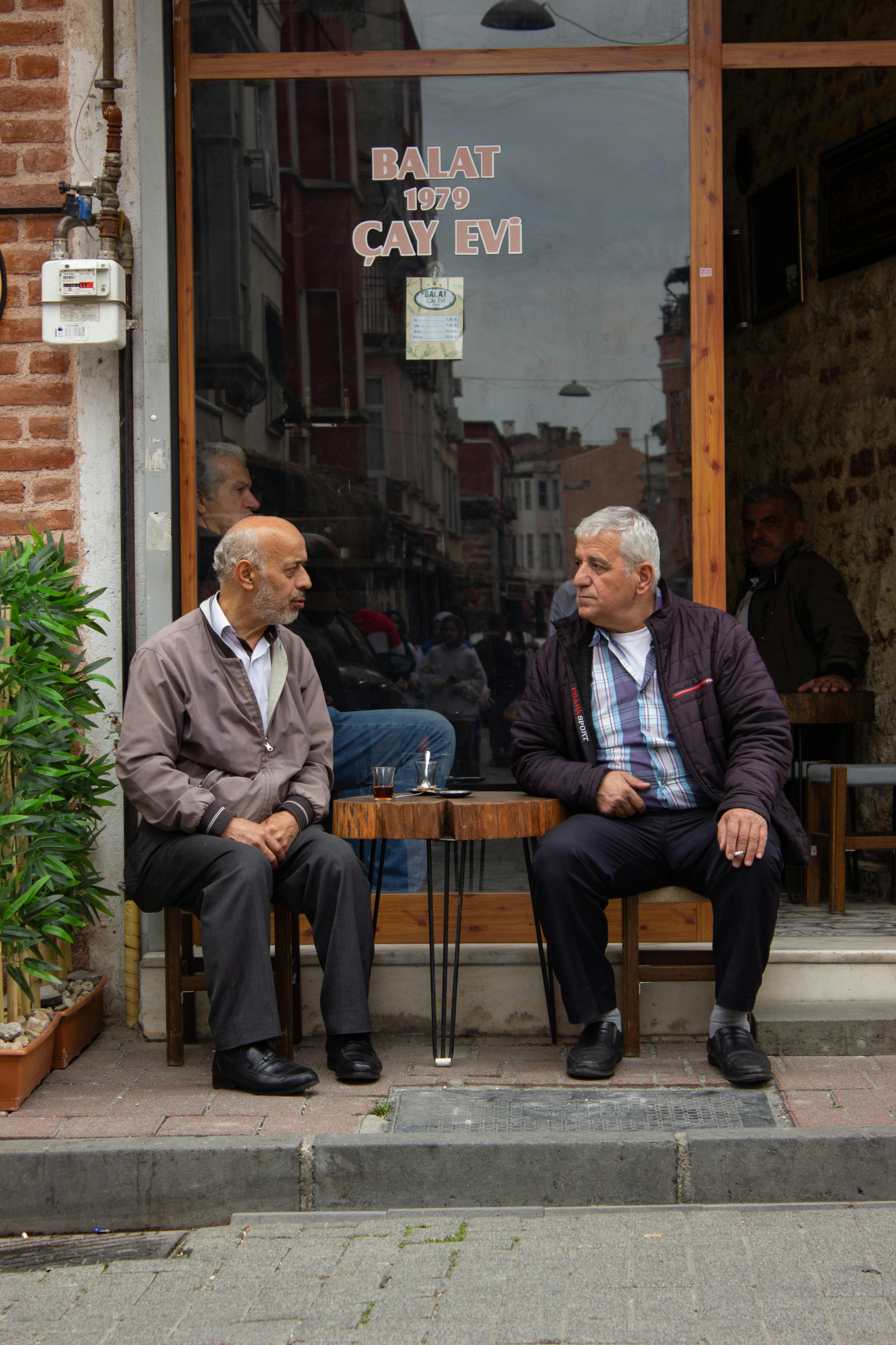 Two Men Conversing Outside Balat Tea House · Free Stock Photo