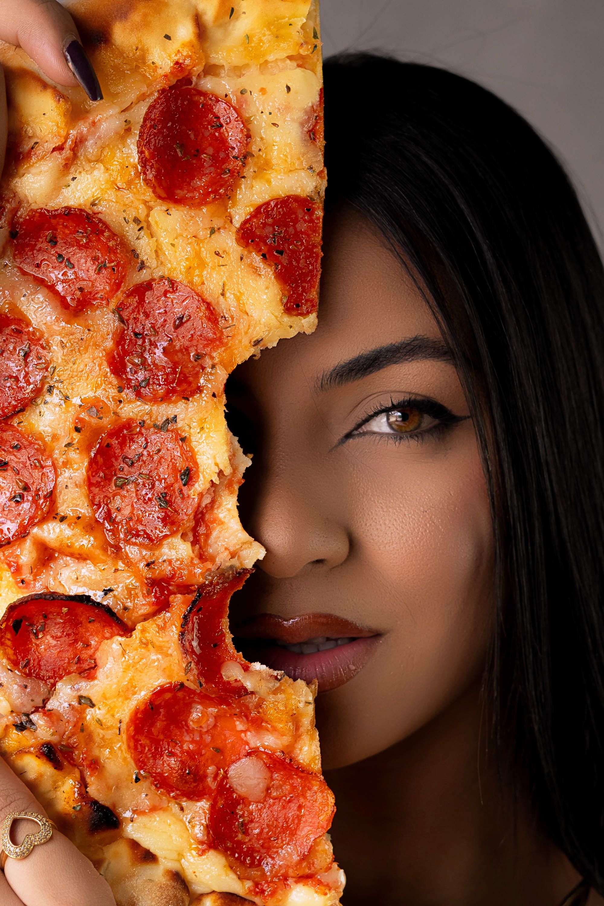 Close-up Portrait of Woman Holding Pepperoni Pizza · Free Stock Photo