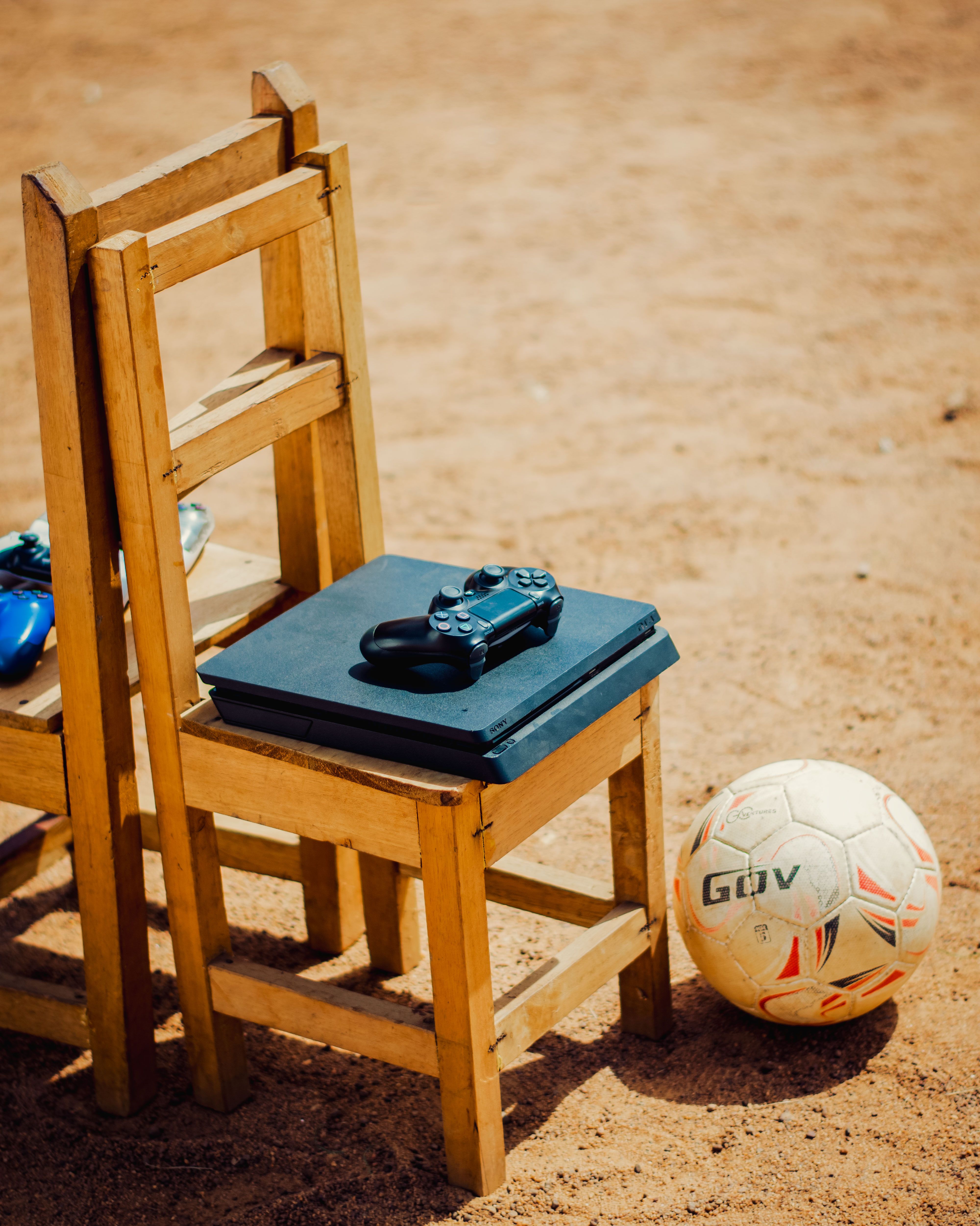 Gaming Console and Ball on Wooden Chairs Outdoors · Free Stock Photo