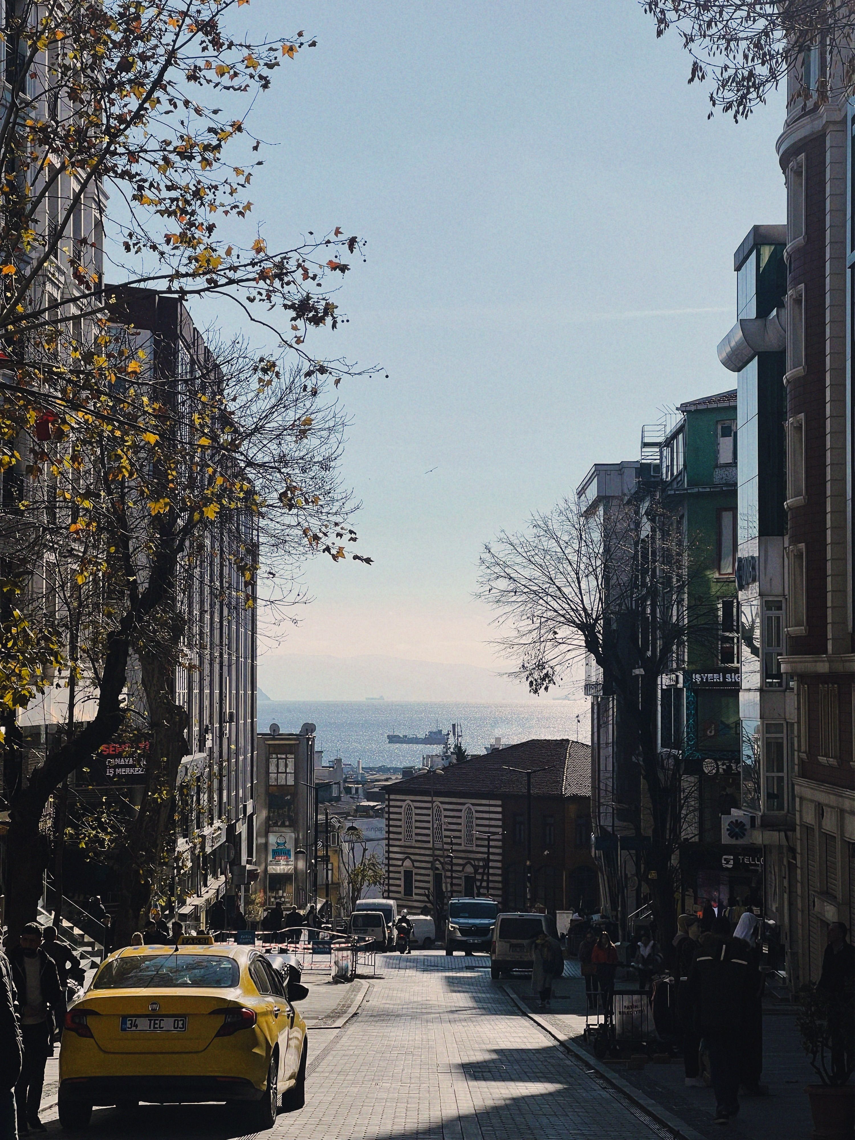 City Street with Ocean View and Yellow Taxi · Free Stock Photo