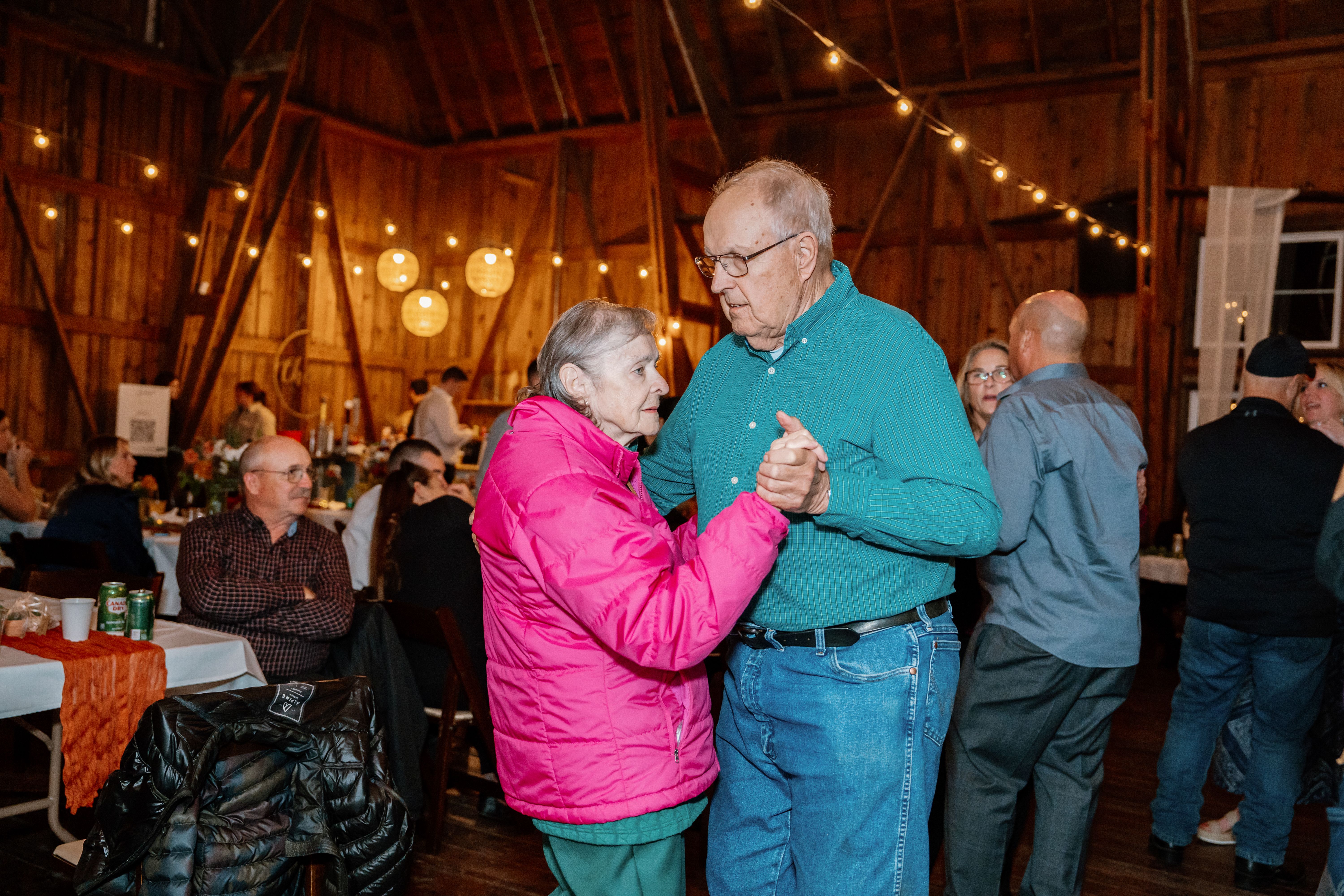 Elderly Couple Dancing at Rustic Barn Event · Free Stock Photo